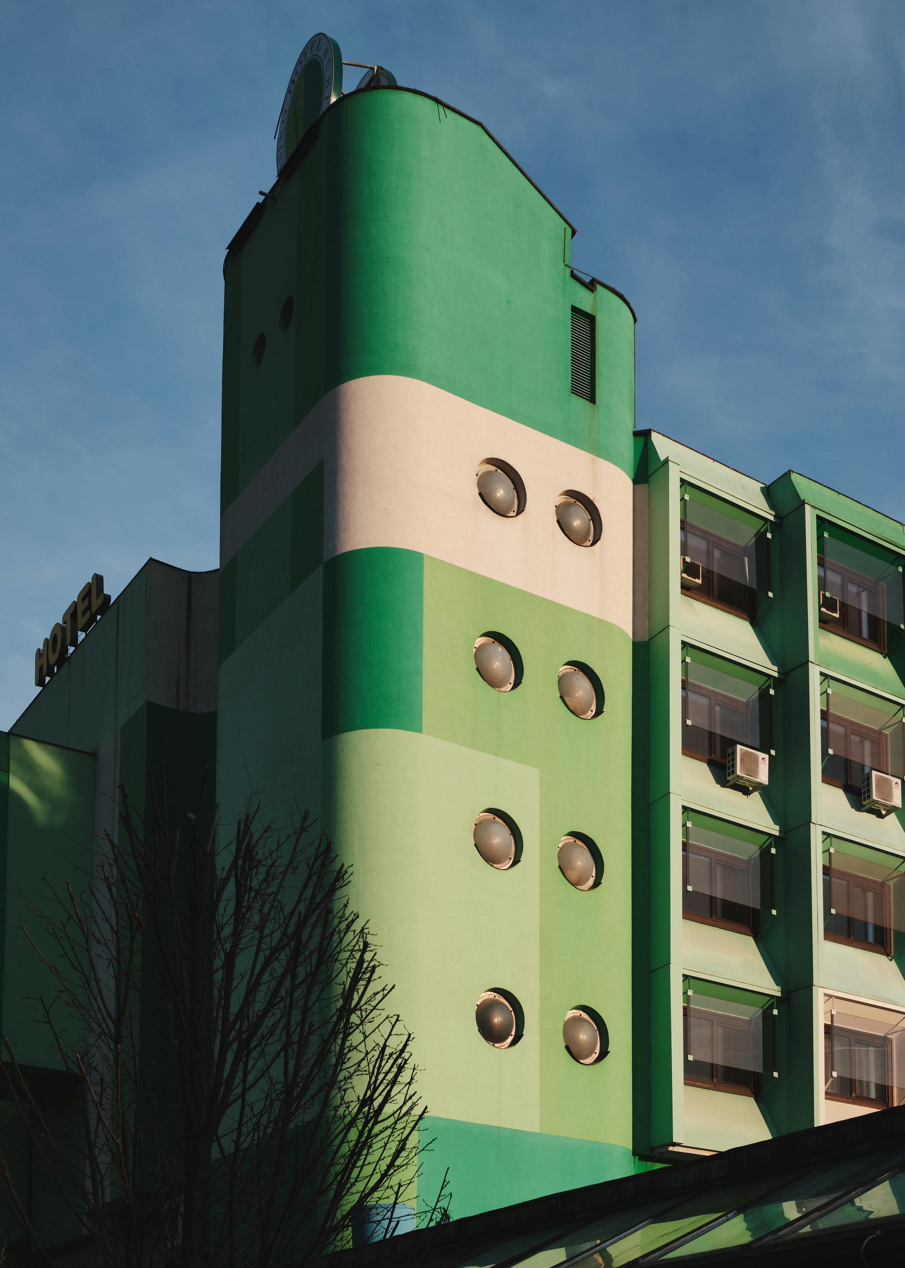 Art Deco Green: Vertical Stripes and Circular Windows on a City Hotel Face