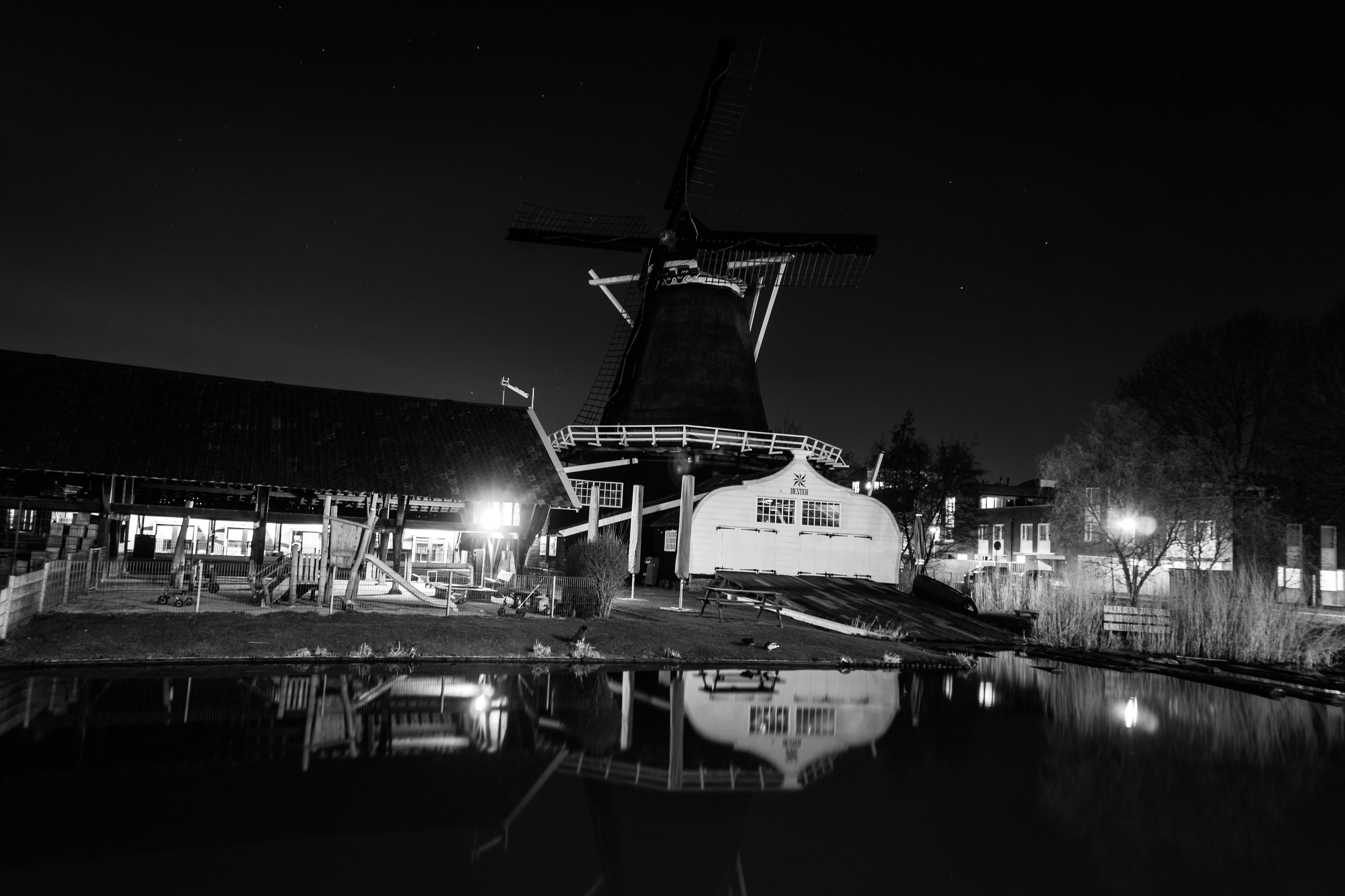 Nocturnal Windmill over a Quiet Canal: Reflections in Black and White