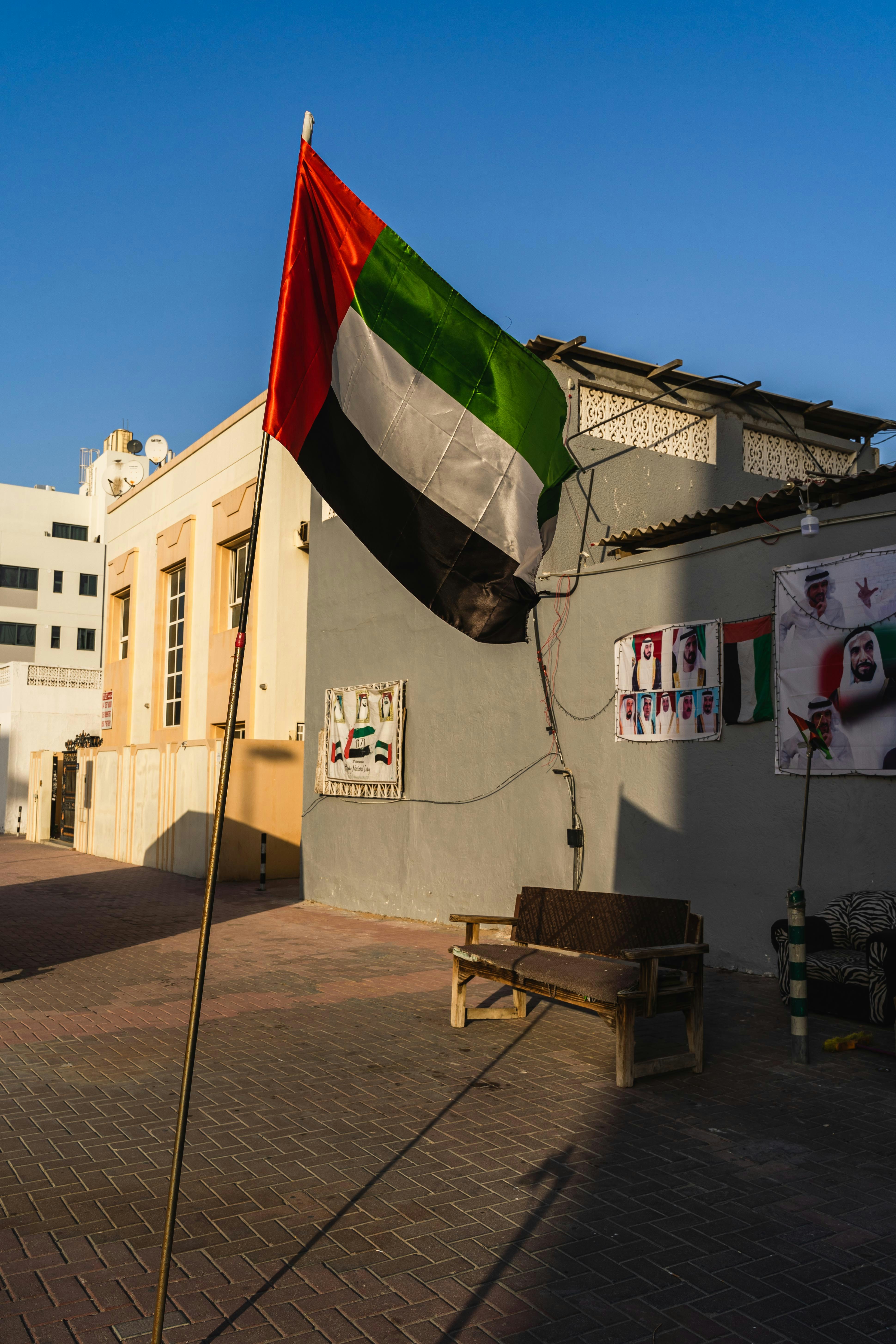 Flag on a Lean Pole Marks a Sunlit Emirati Street