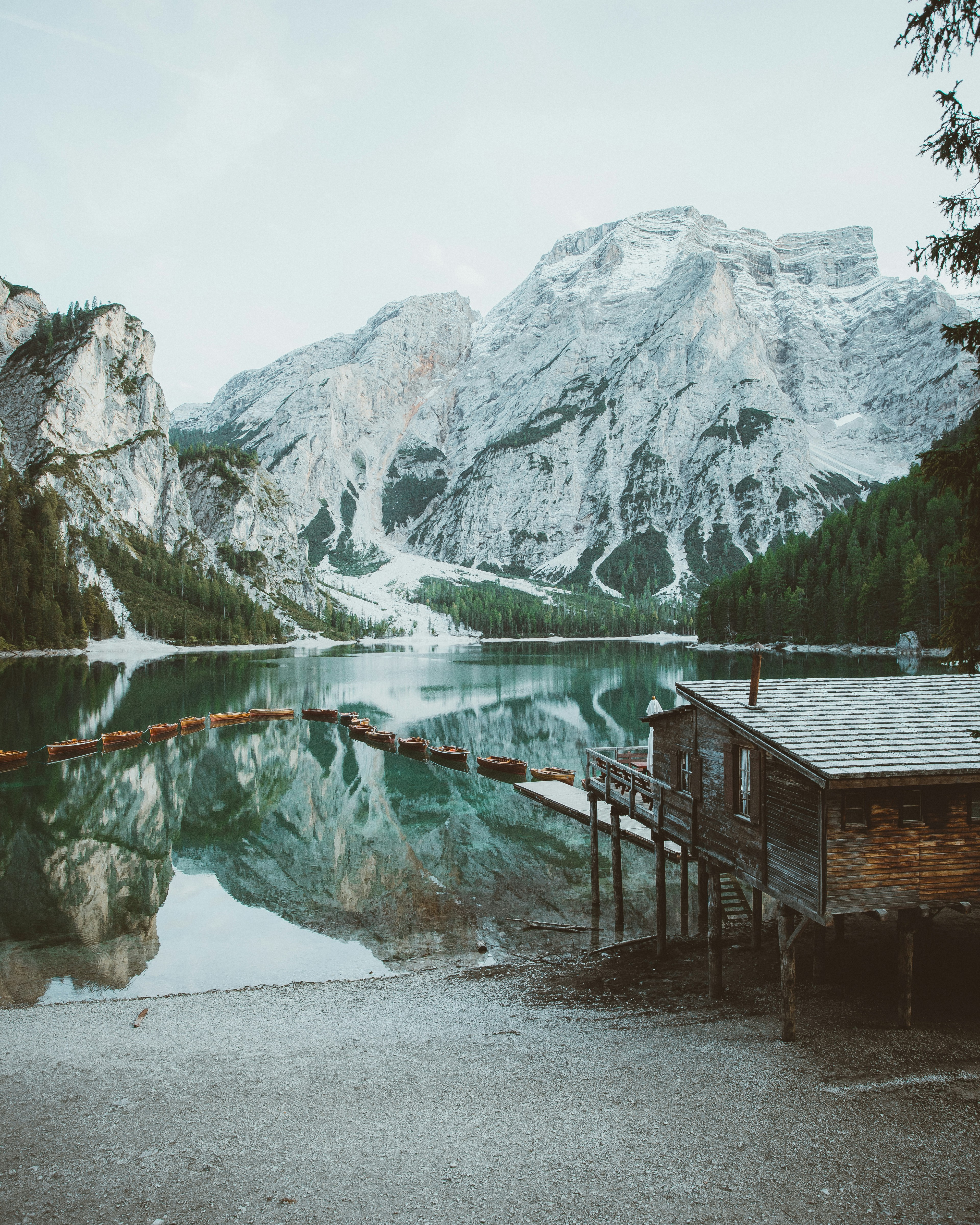 Alpine Mirror: A Weathered Dock Framed by Snowlit Peaks