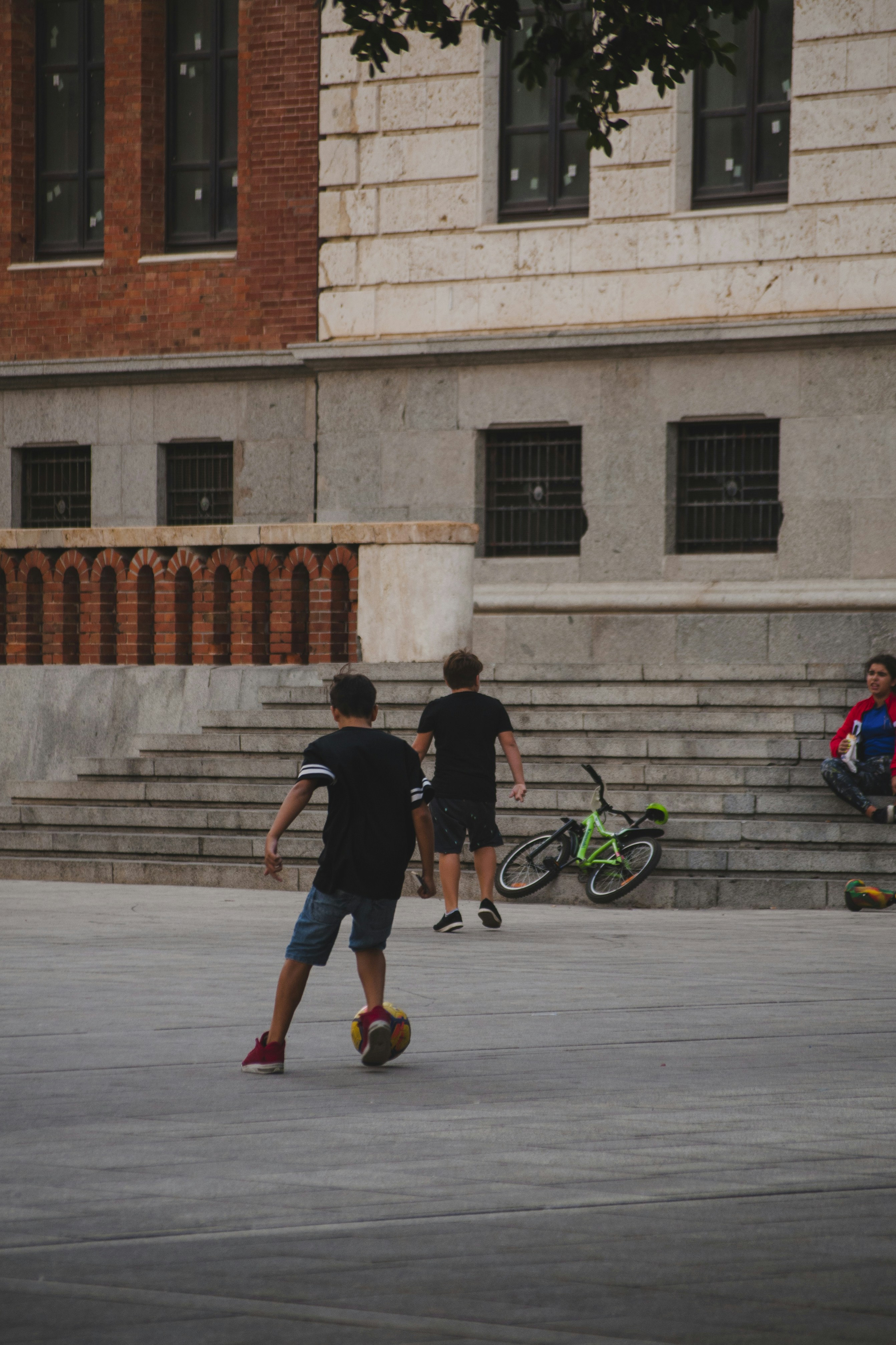 Urban Kick: A Boy Commands the Ball in a Sunlit Plaza