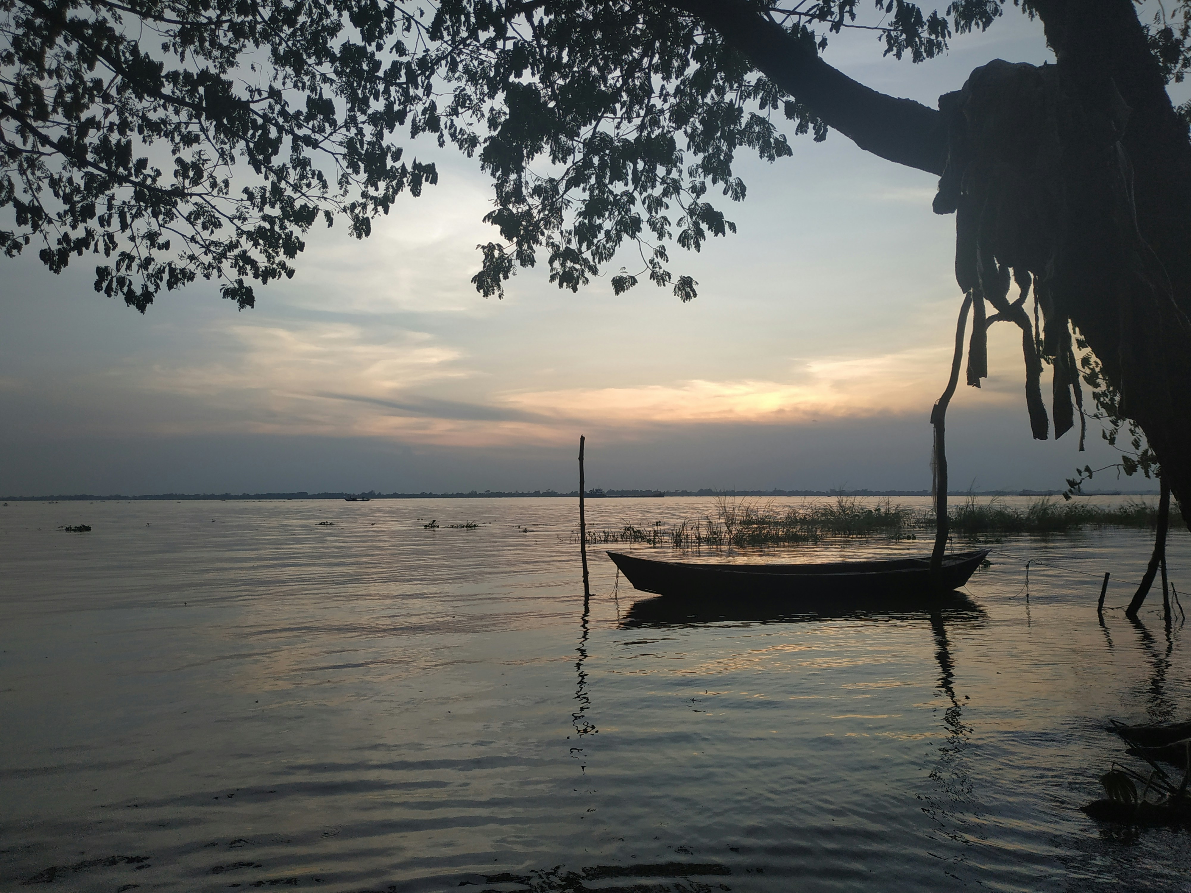 Boat Silhouette at Dusk: A Quiet Riverside Moment