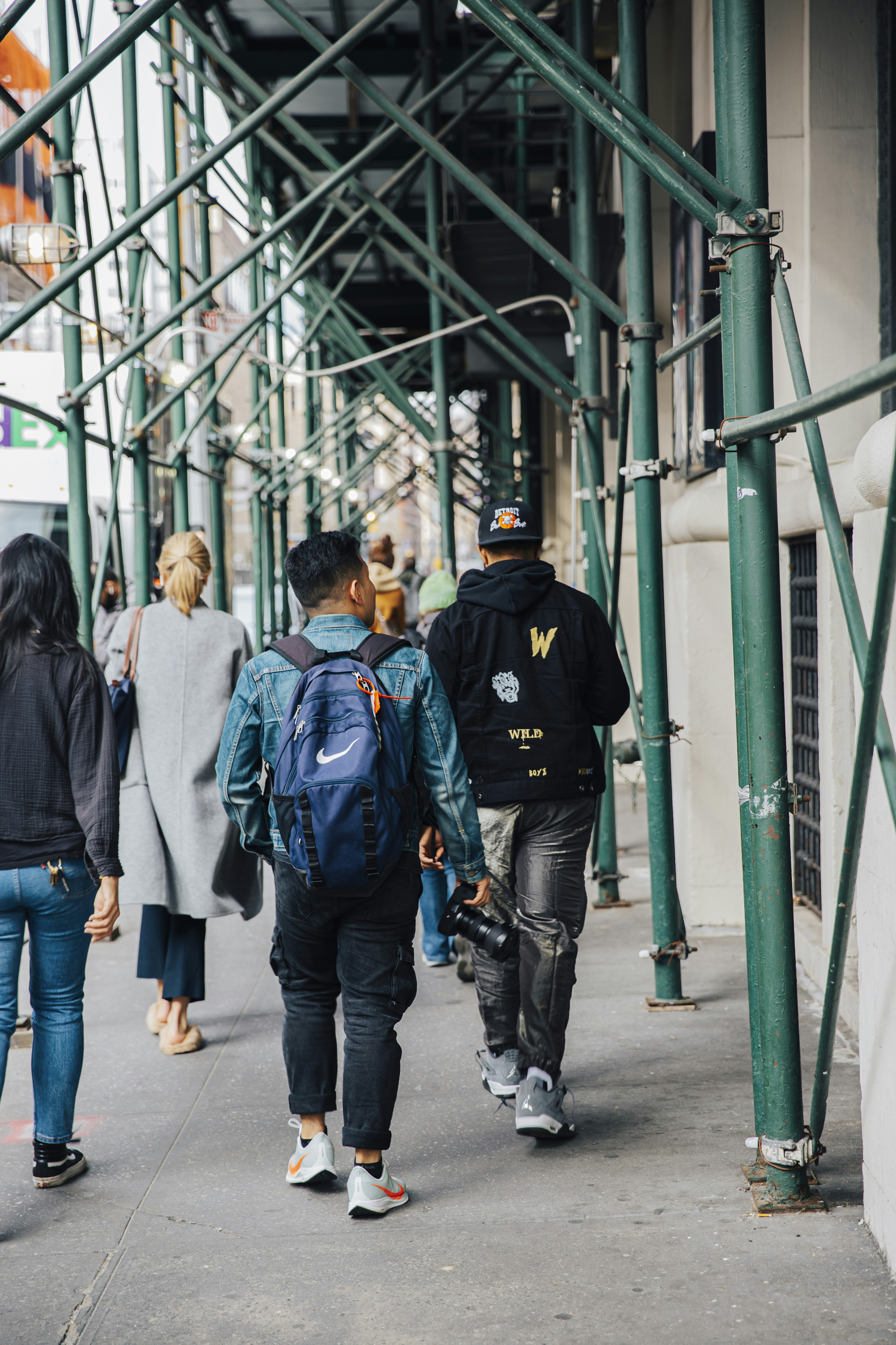 Under the Green Skeleton: Pedestrian Ballet Along a Scaffolding Corridor