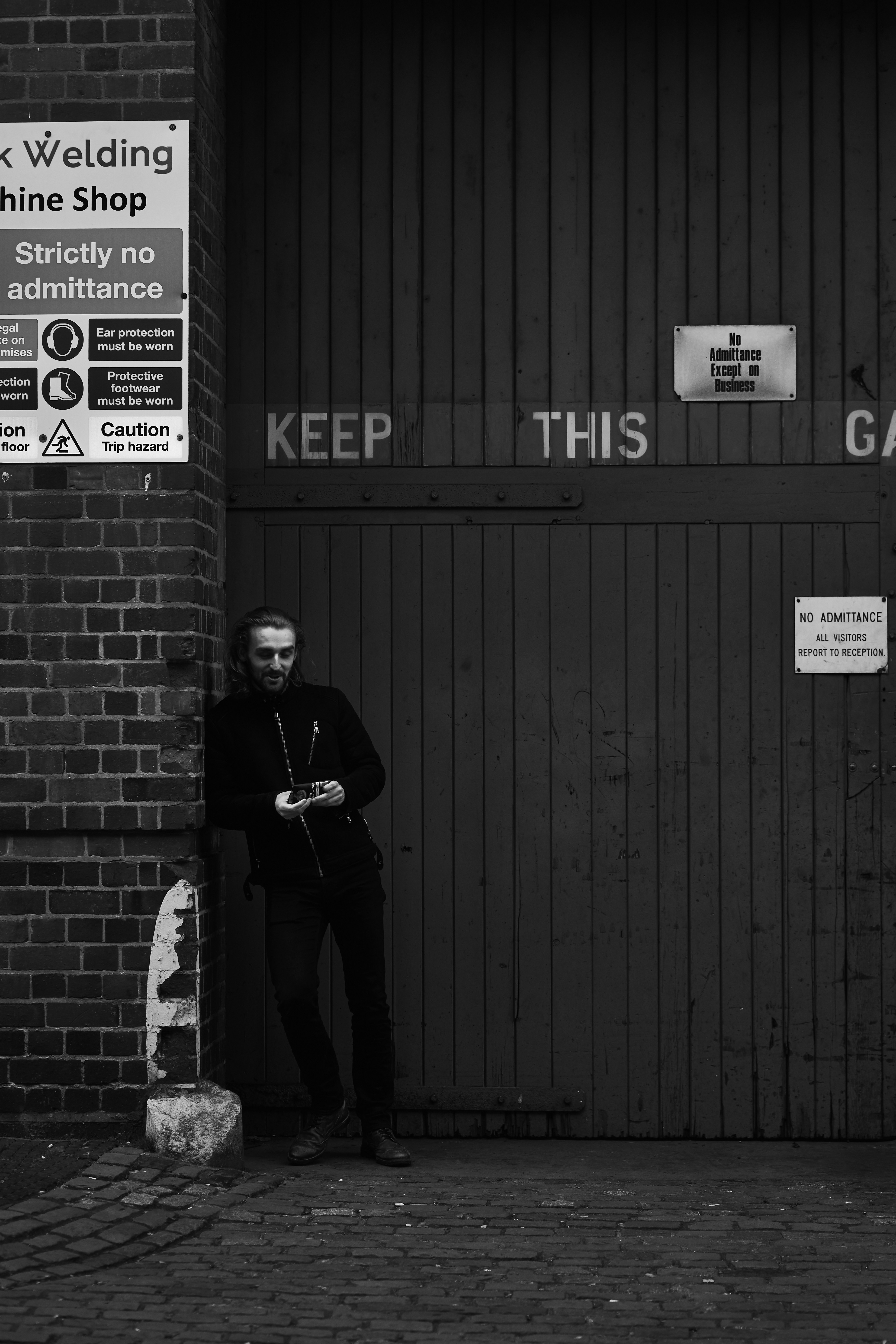 A man leaning on the industrial building