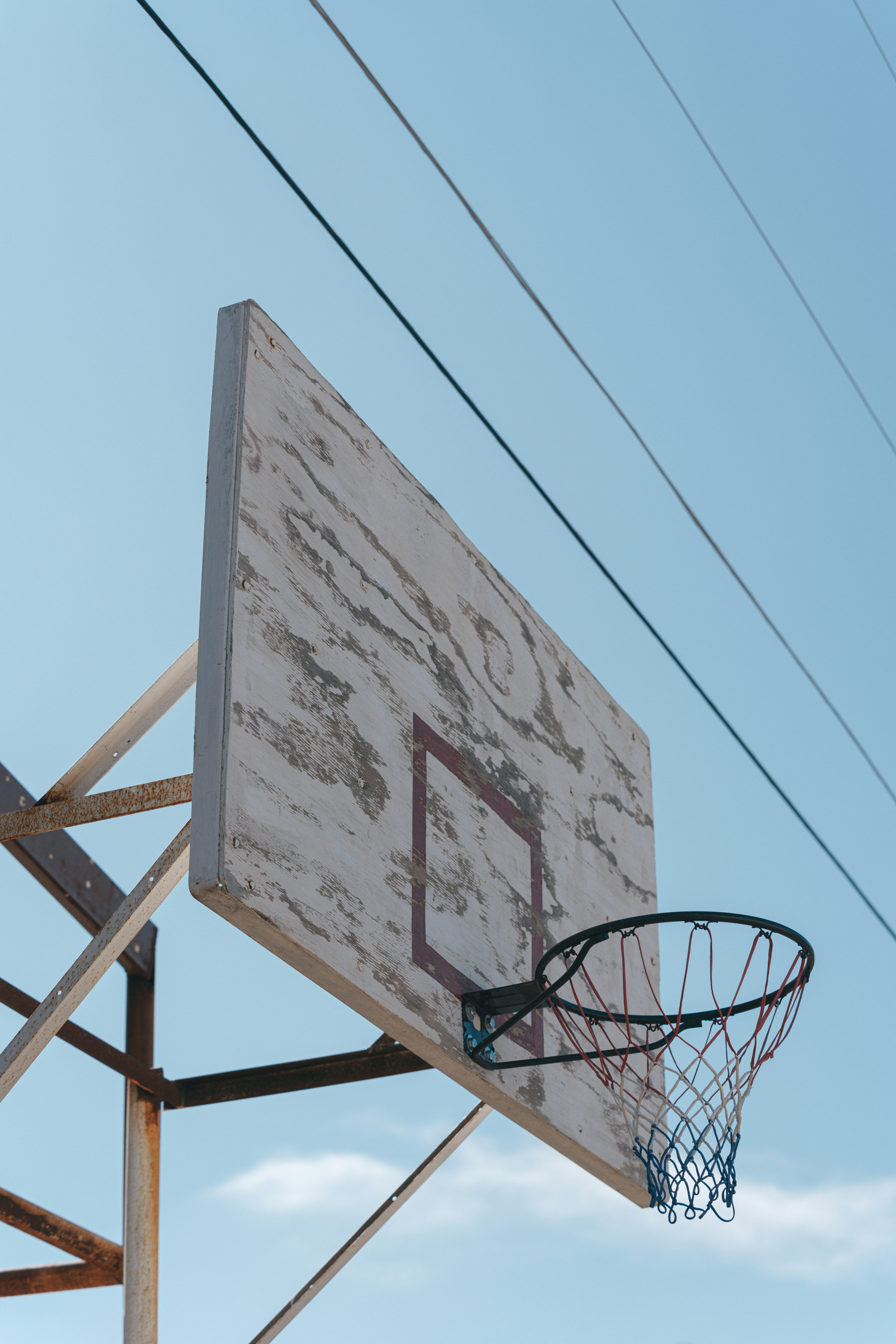 Rusted Rim Against a Clear Sky: A Weathered Basketball Scene