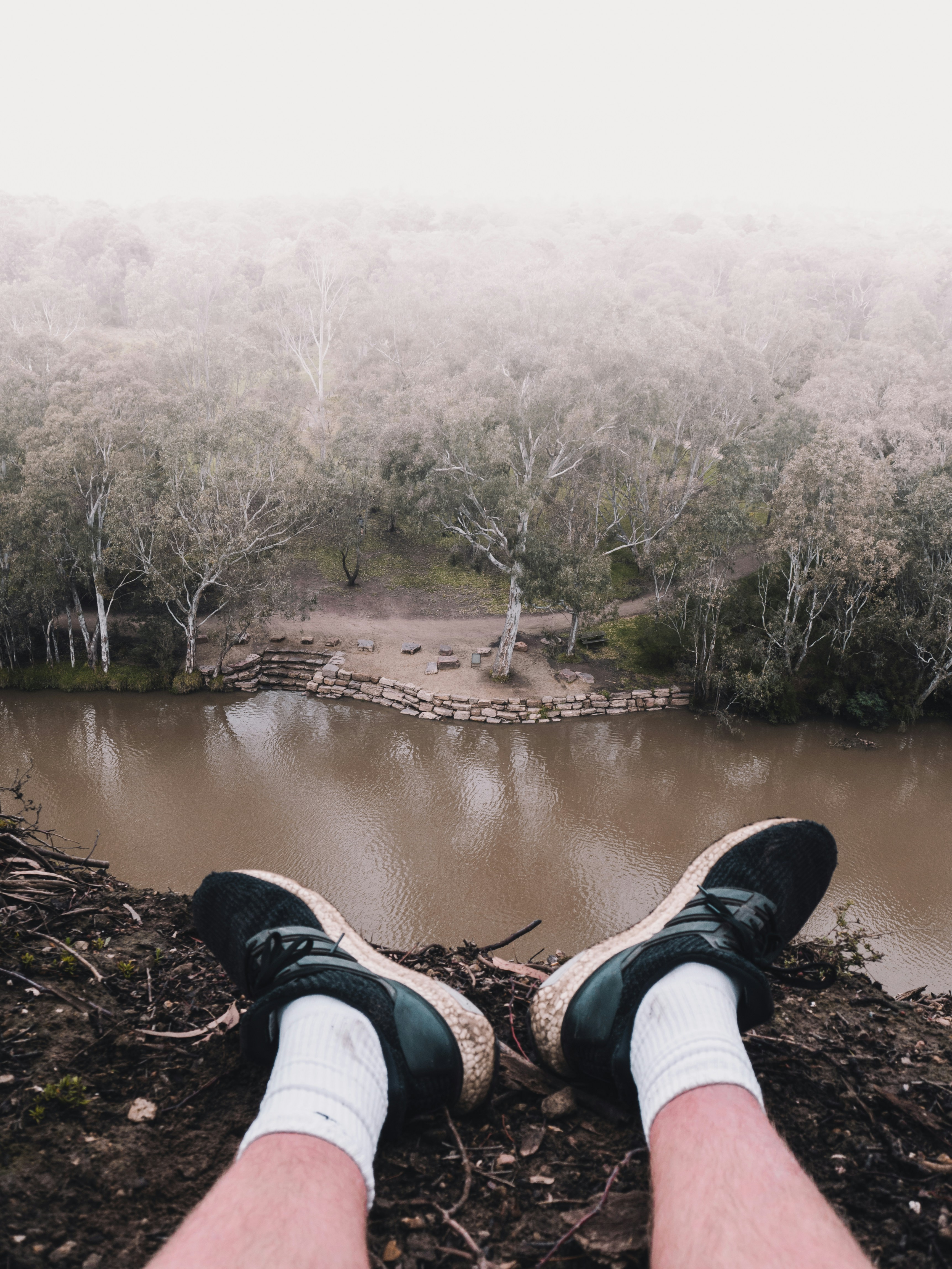 Boots Over the Brink: Fog-Soft Riverside Vista