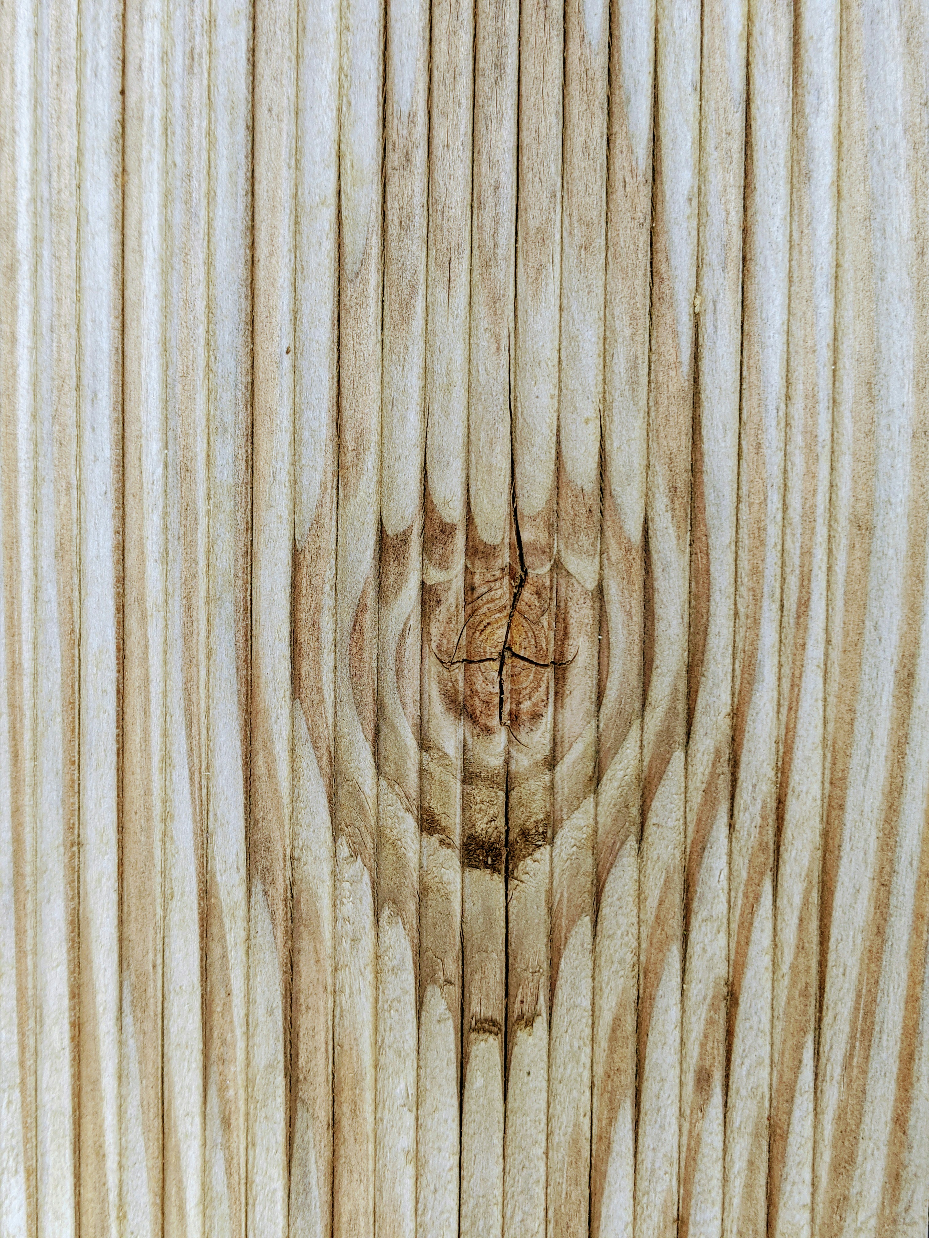 Close-up of wooden planks showcasing natural grain patterns and a central knot, highlighting the beauty of organic textures.