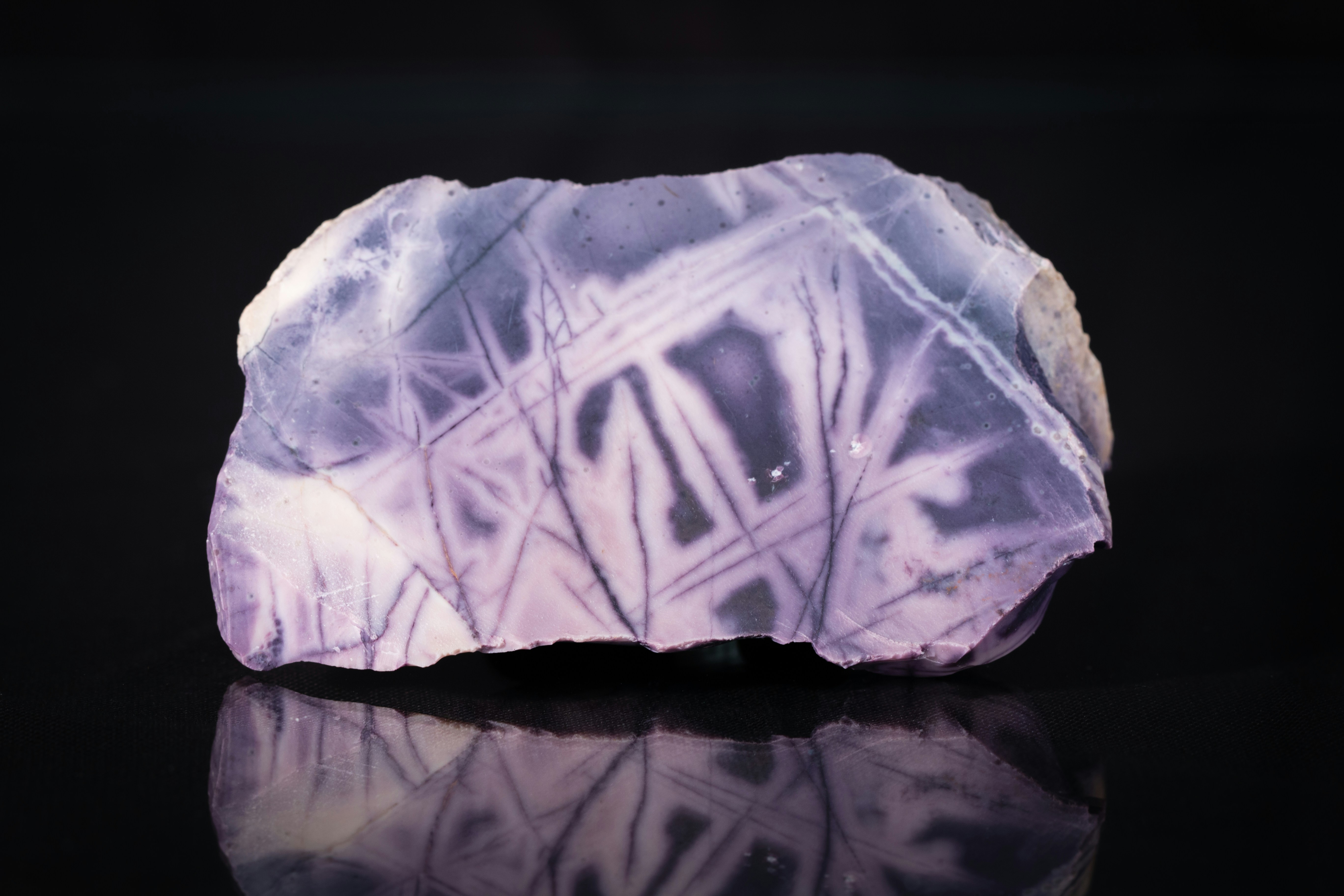 Intricate Purple Lithic Glyphs on a Reflective Stone