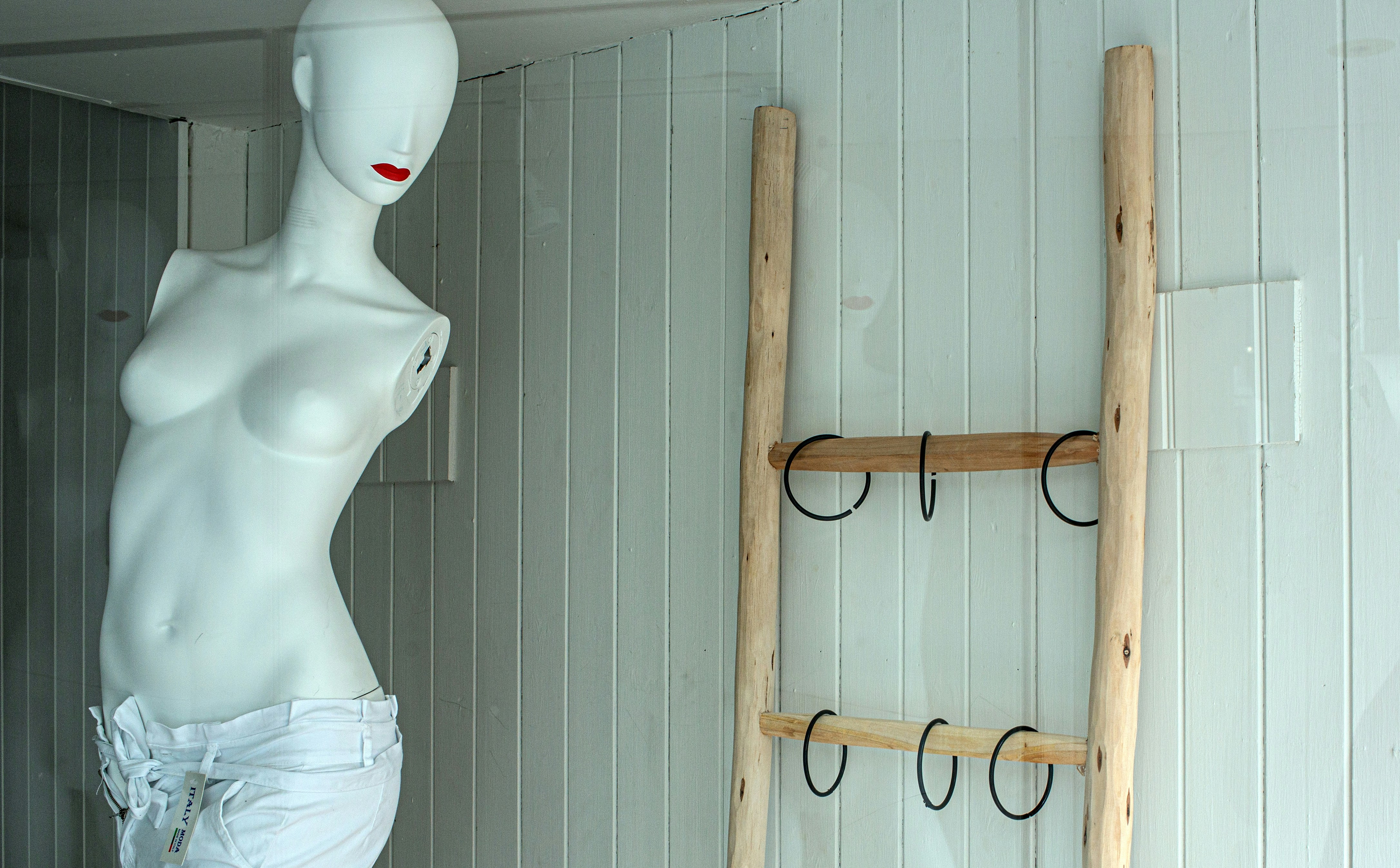 Lone White Torso in Soft Studio Light by a Rustic Wooden Ladder