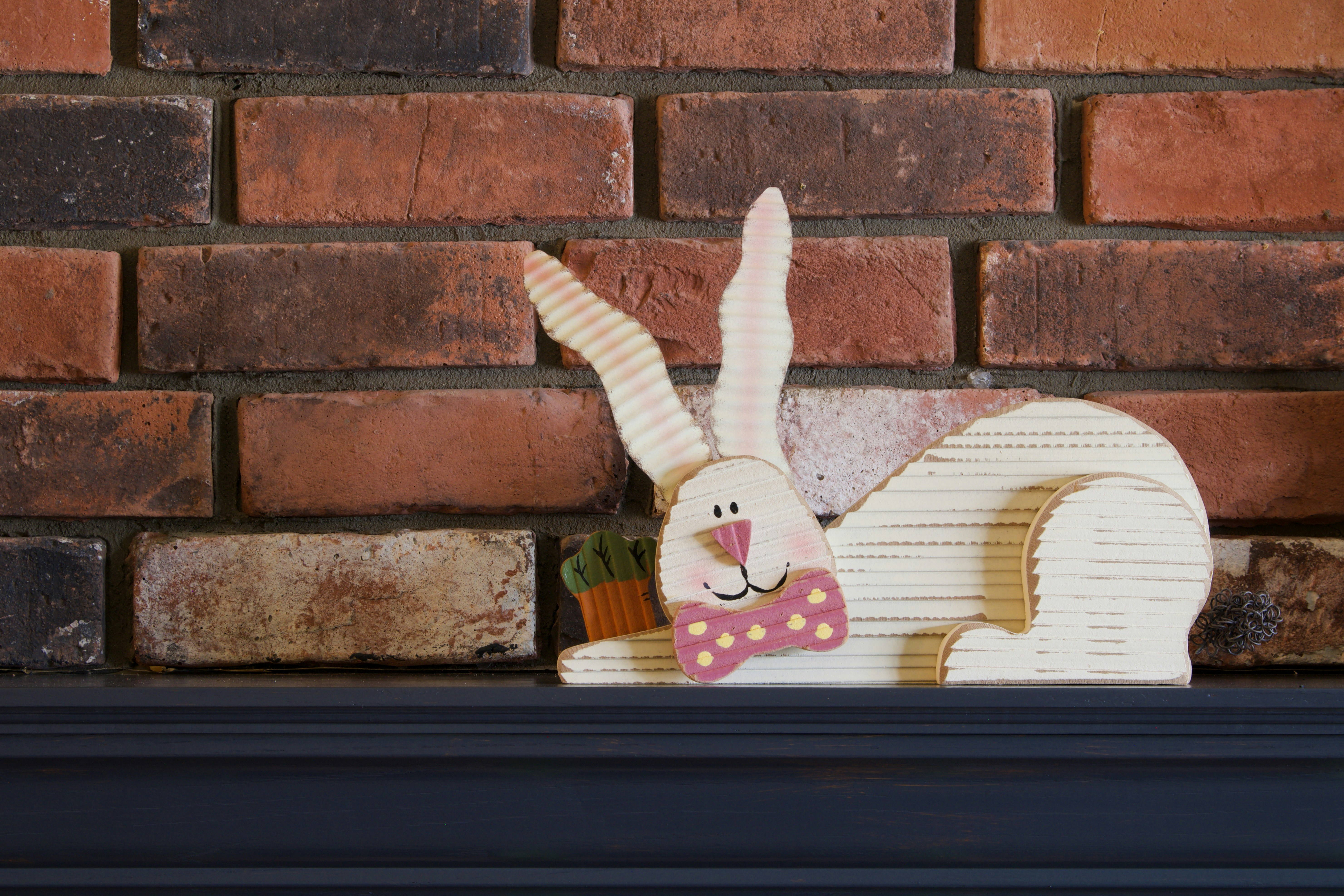 Porcelain Bunny at Dusk: A Brick Wall Keeps Watch