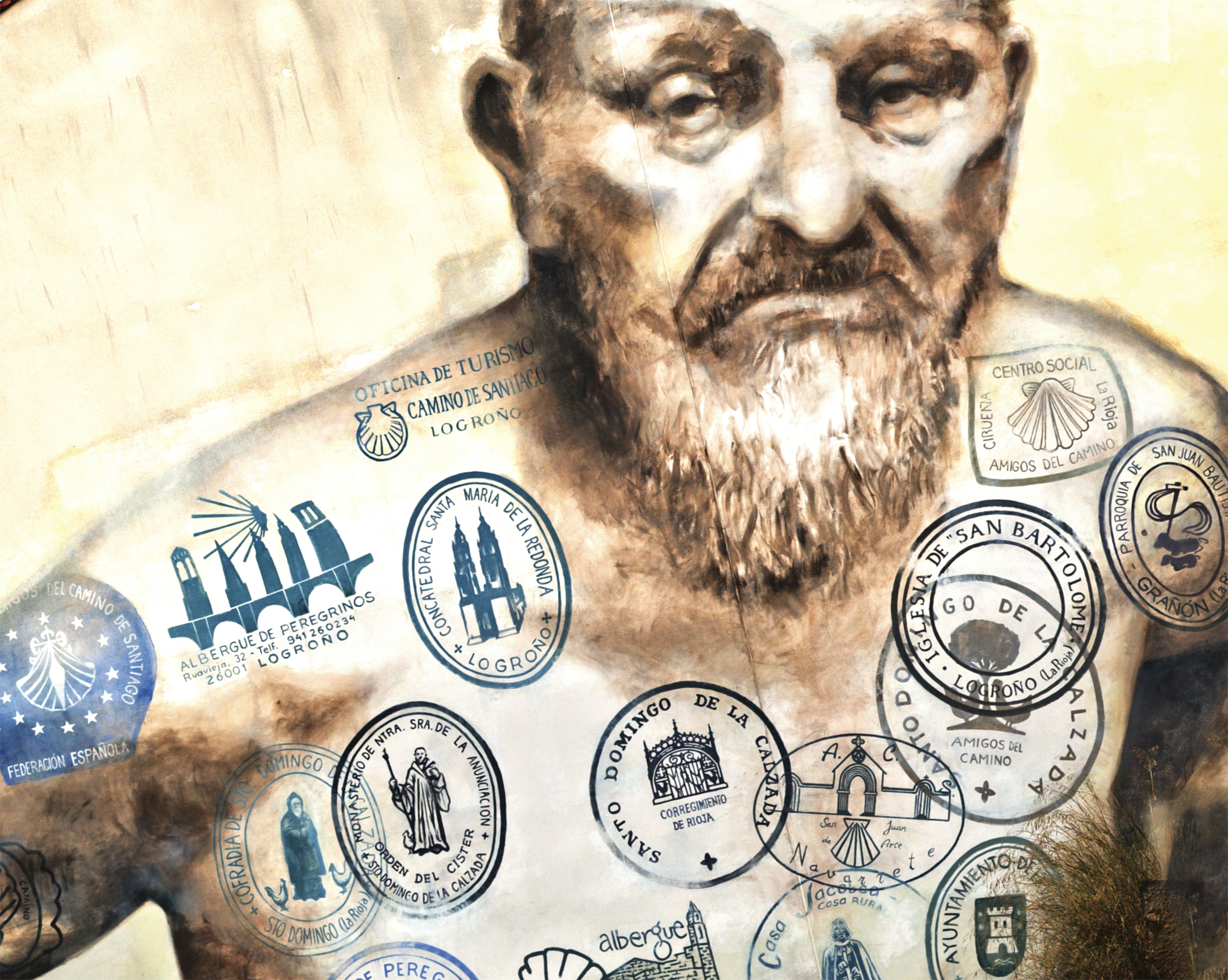 Artistic illustration of a bearded man with various stamps and symbols across his chest.