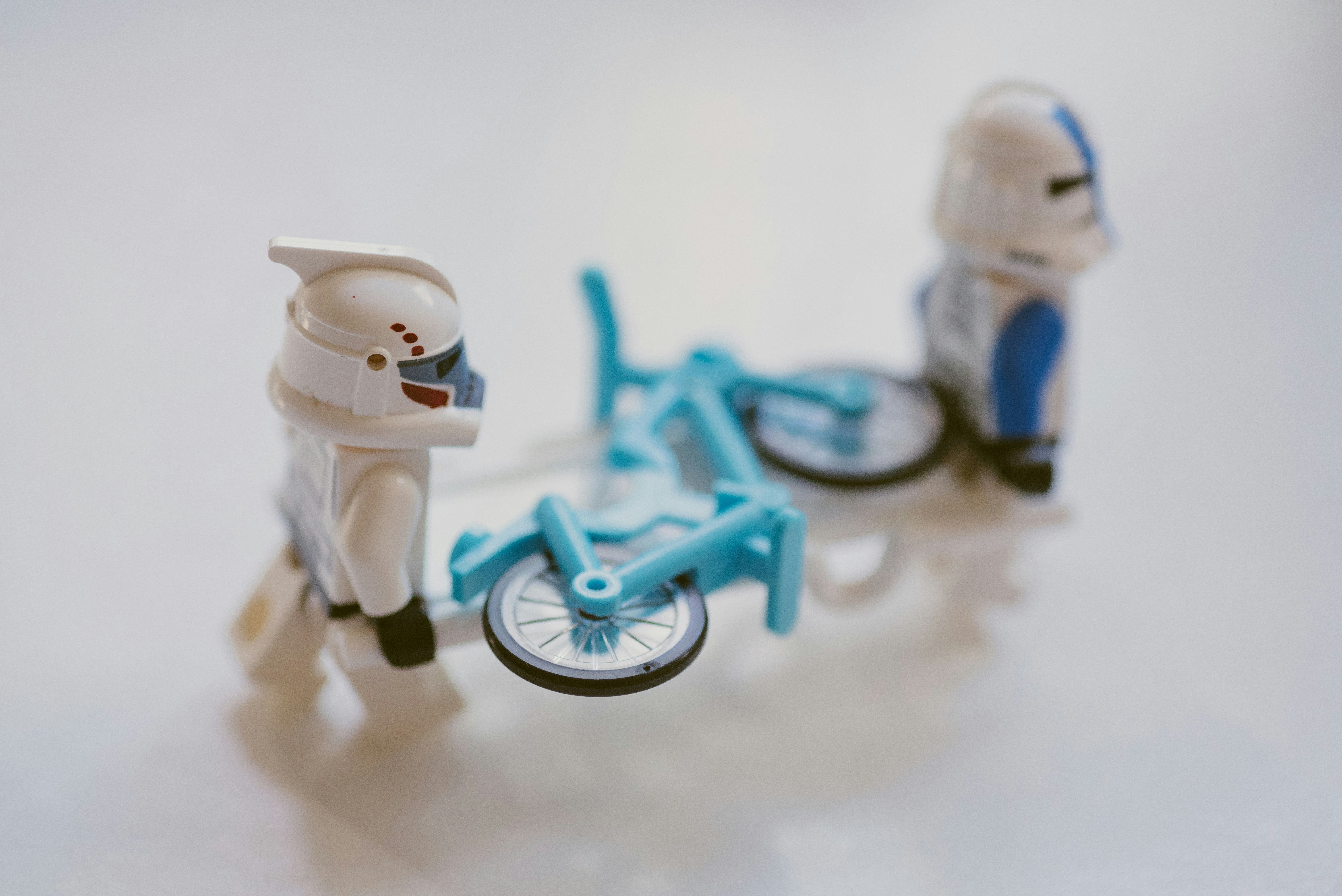 Two LEGO® minifigures carrying a bicycle