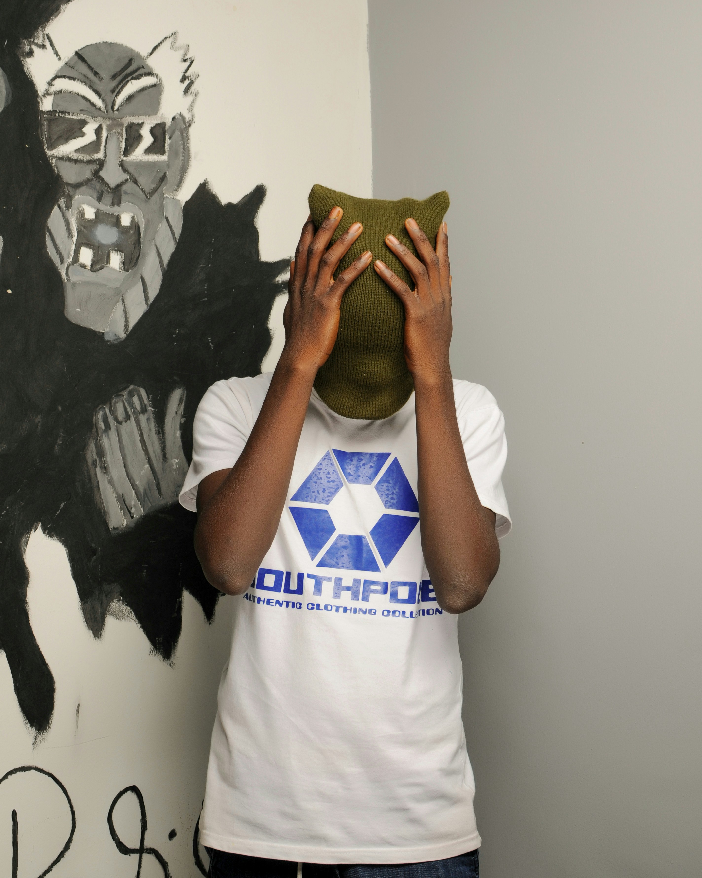 Green Veil at the Corner: A Masked Moment Beside a Graffiti Demon