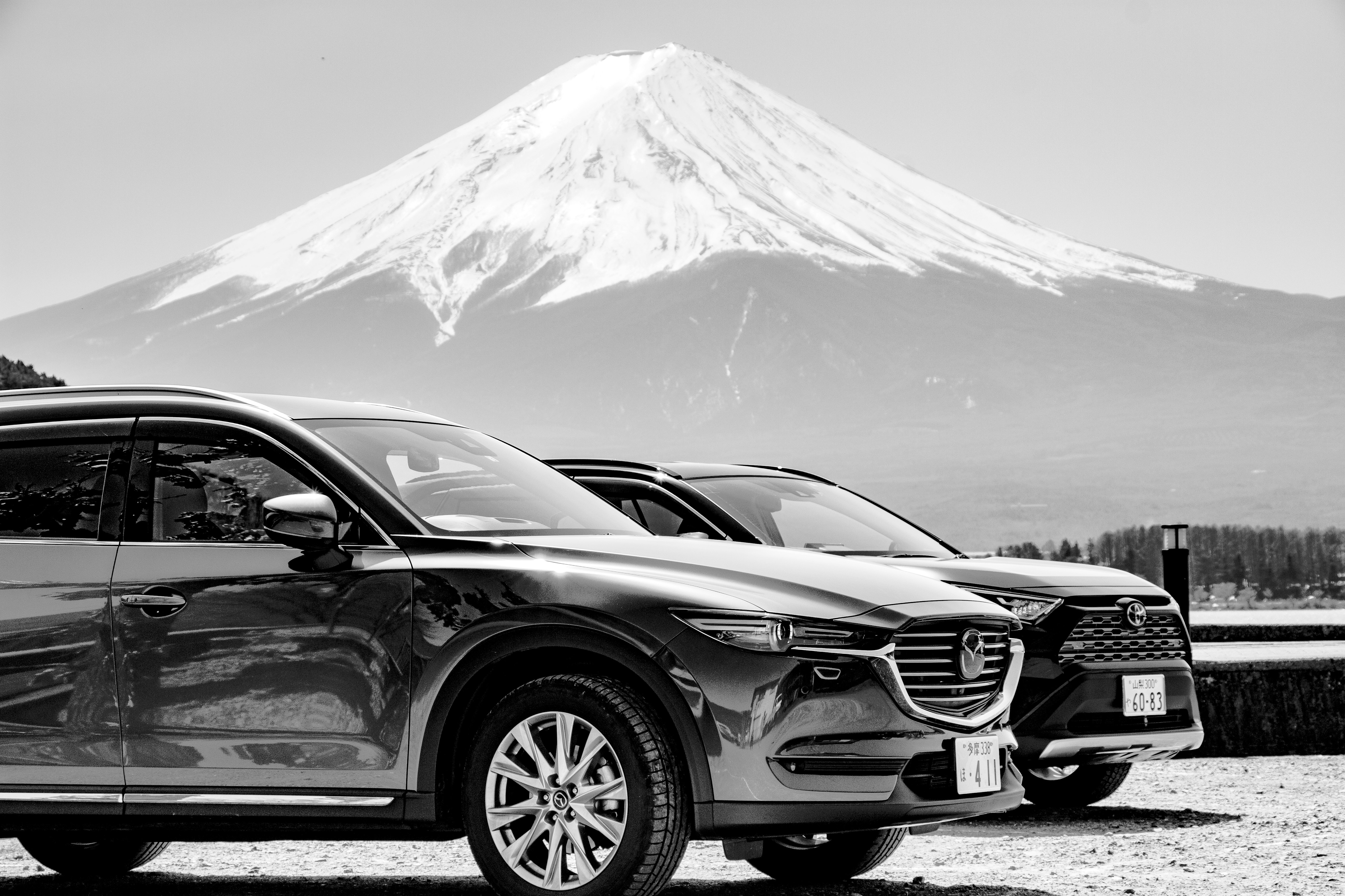 Torque and Summit: Cars Parked at the Foot of a Snow-Capped Peak