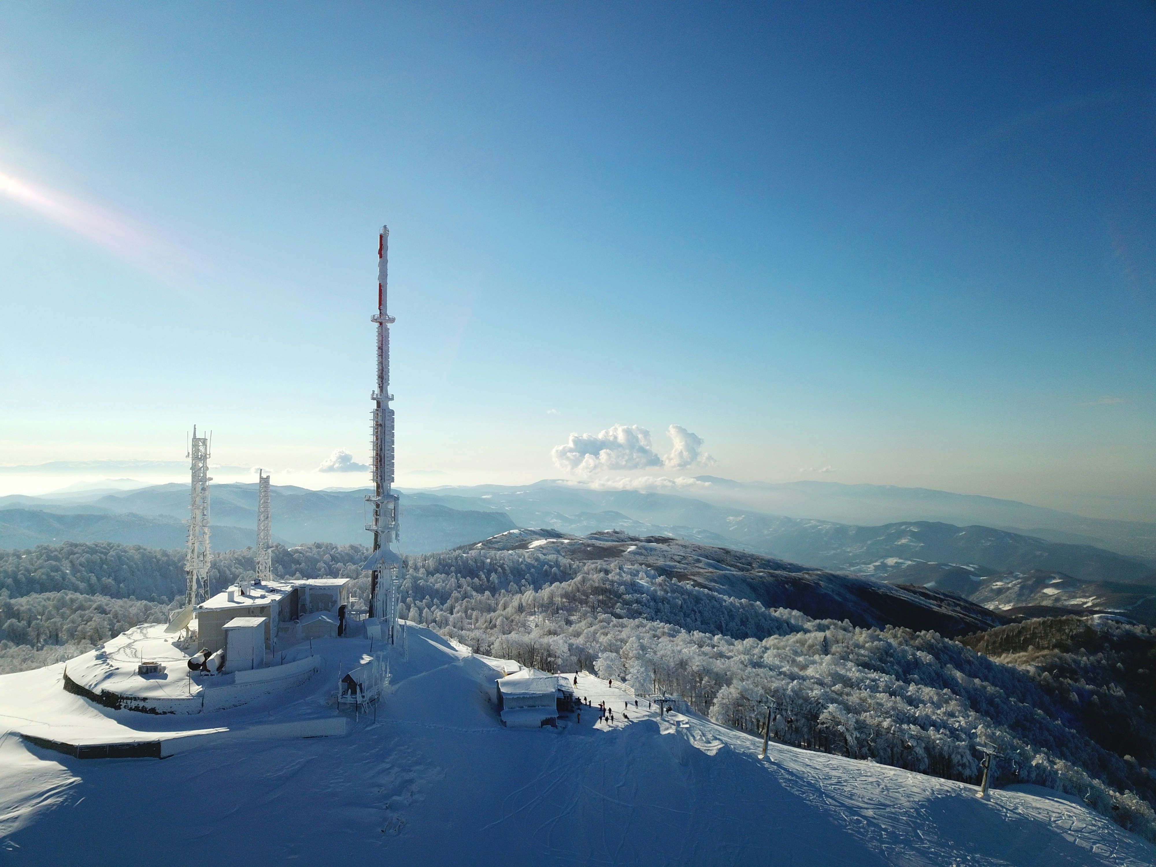 Snow-Capped Summit and Tower Array: A Quiet Aerial Overlook