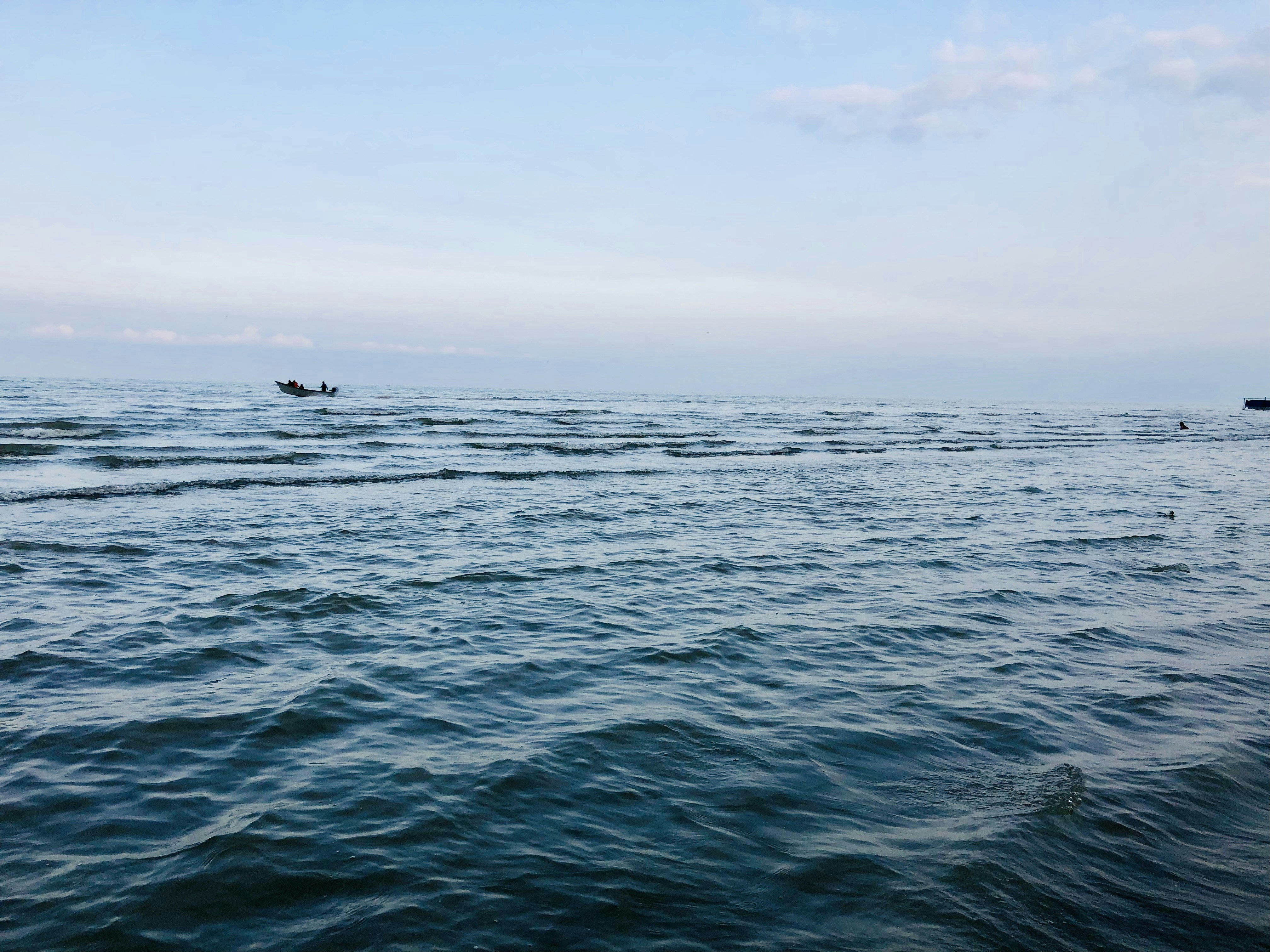 Expansive view of the Caspian Sea with gentle waves under a clear summer sky.