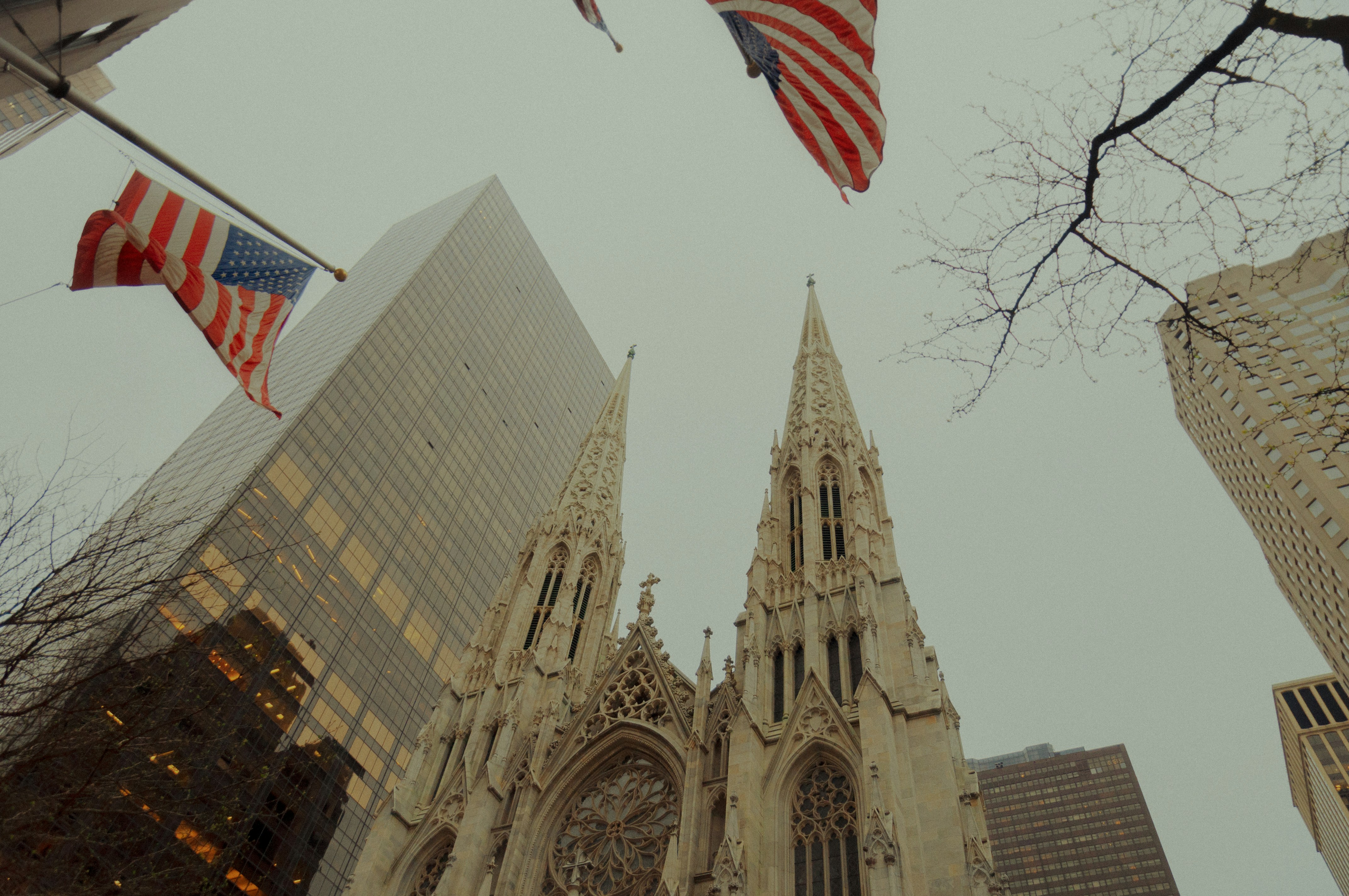 Gothic Facade Framed by Modern Skyscrapers and Fluttering Flags