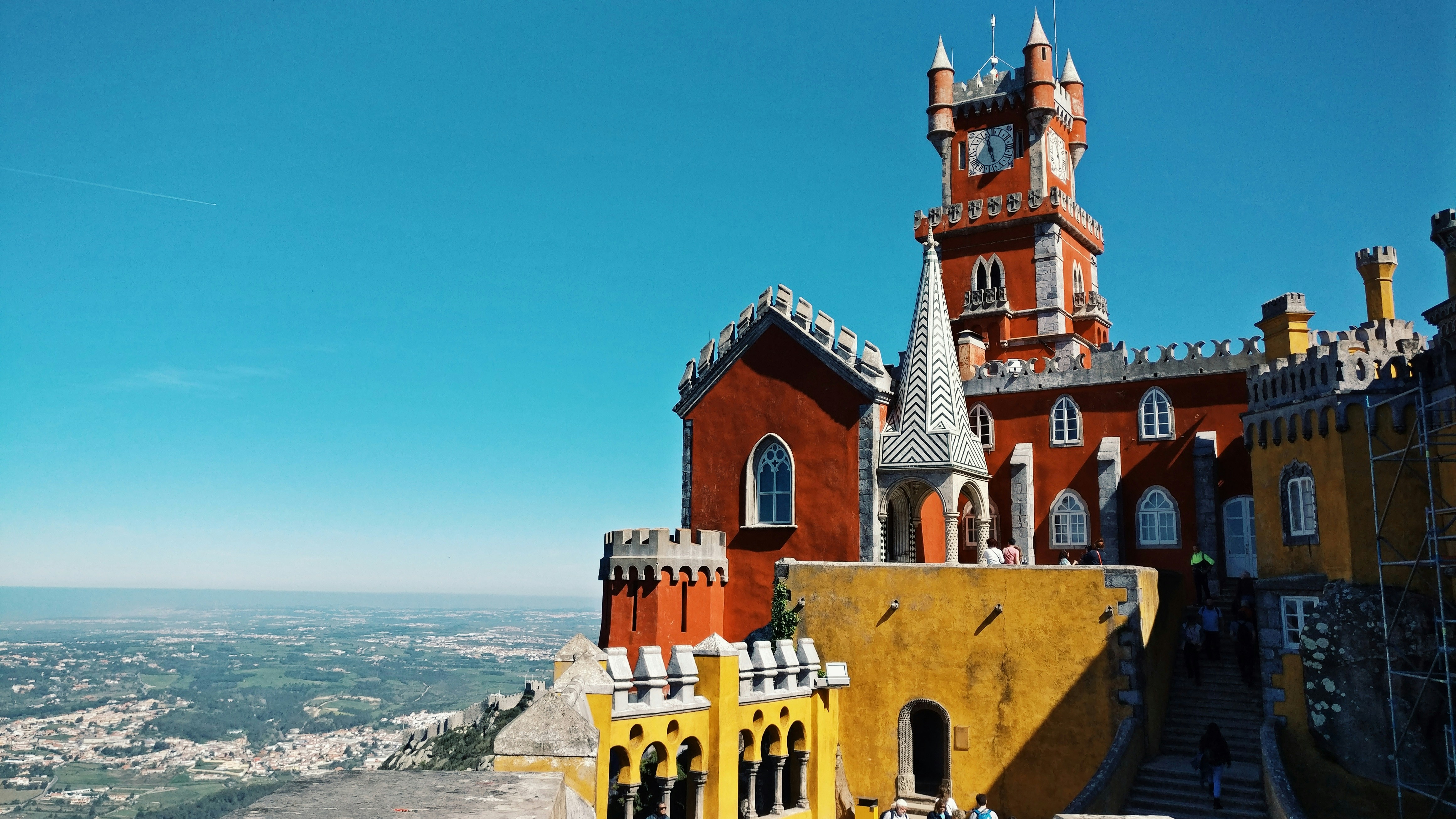Colorful castle with intricate architecture against a clear blue sky.