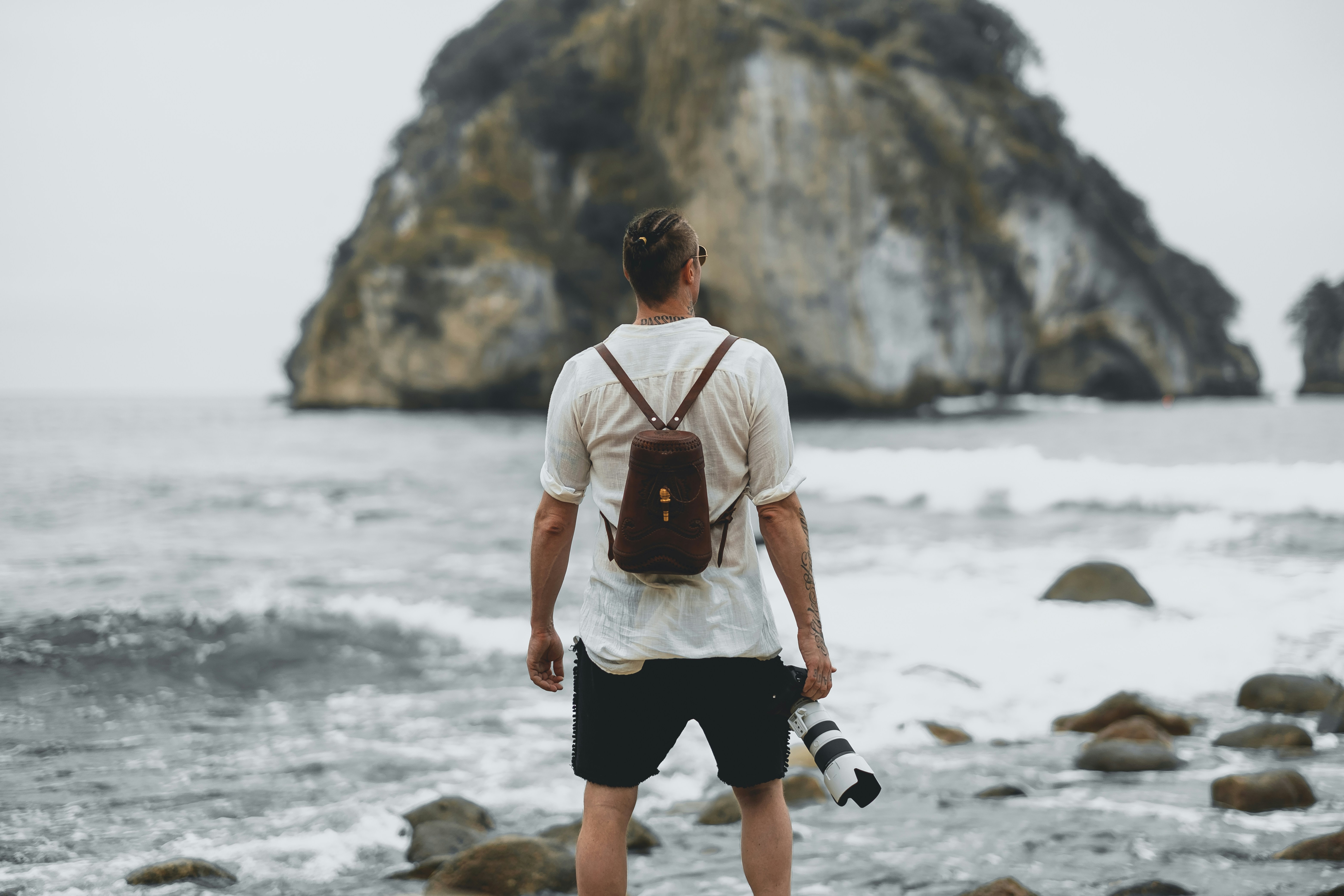 Shoreline Standoff: A Traveler's Quiet Gaze Toward Sea Stacks