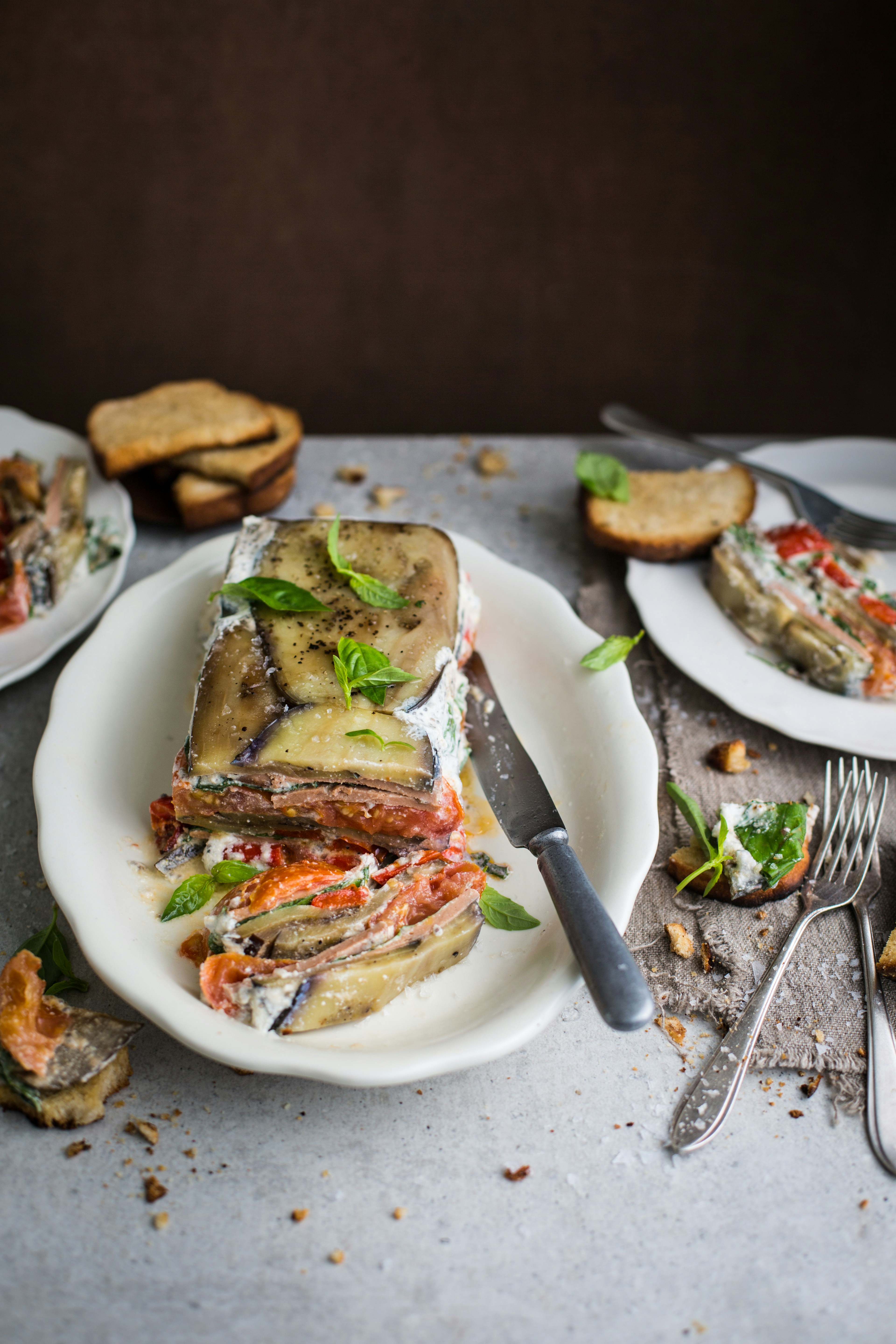 Layered Eggplant Stack with Tomato and Basil on a Rustic Table