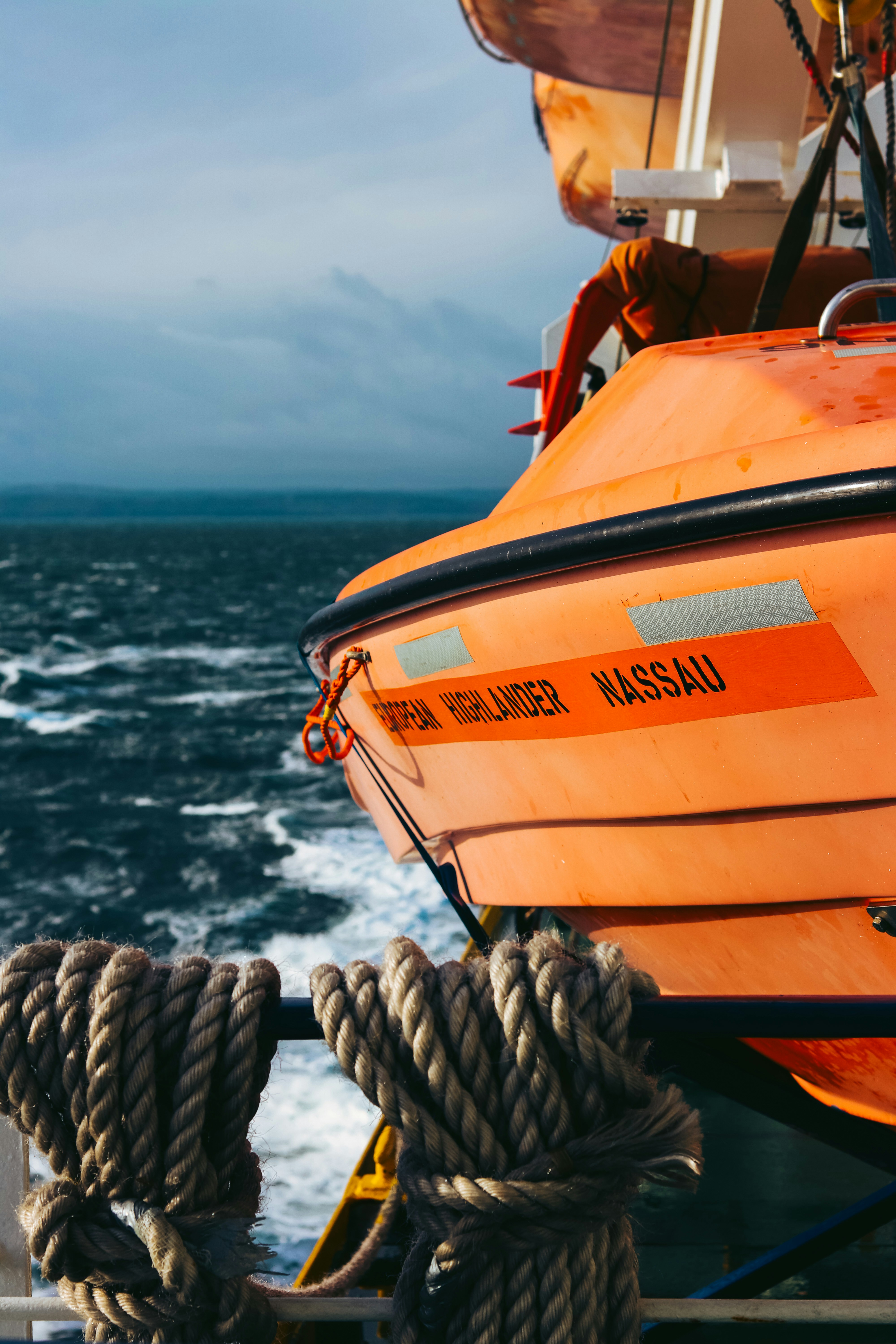 Orange Lifeboat at Sea: A Rope-Burnished Deck in Motion
