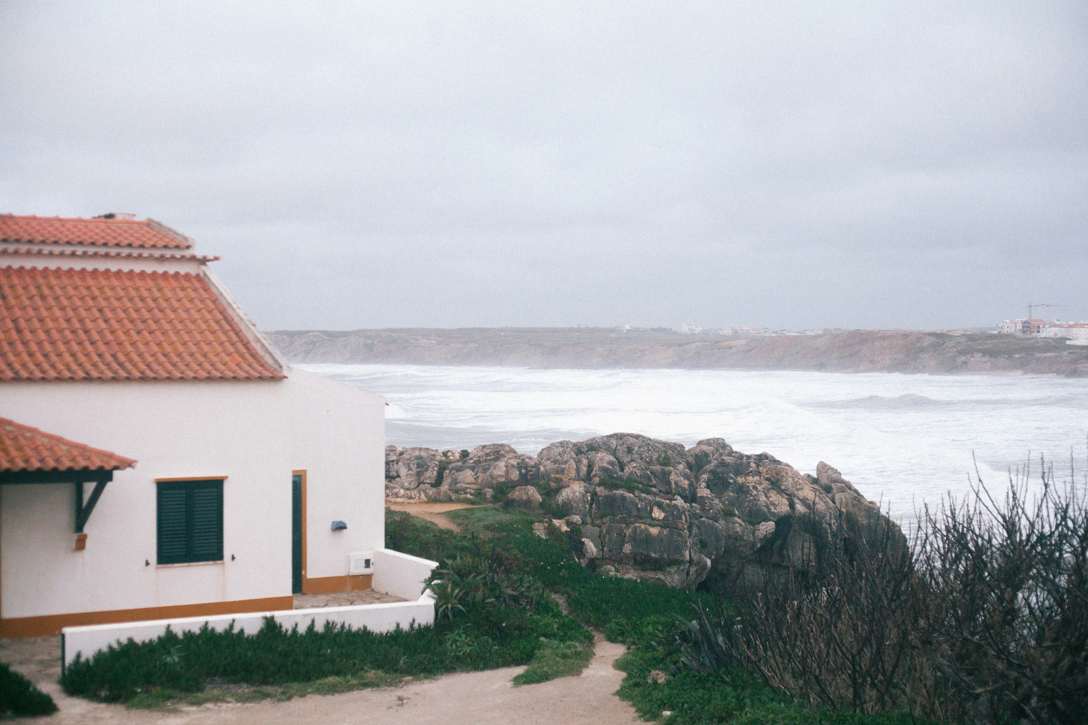 White-walled Cottage at the Edge of a Grey Atlantic Shore