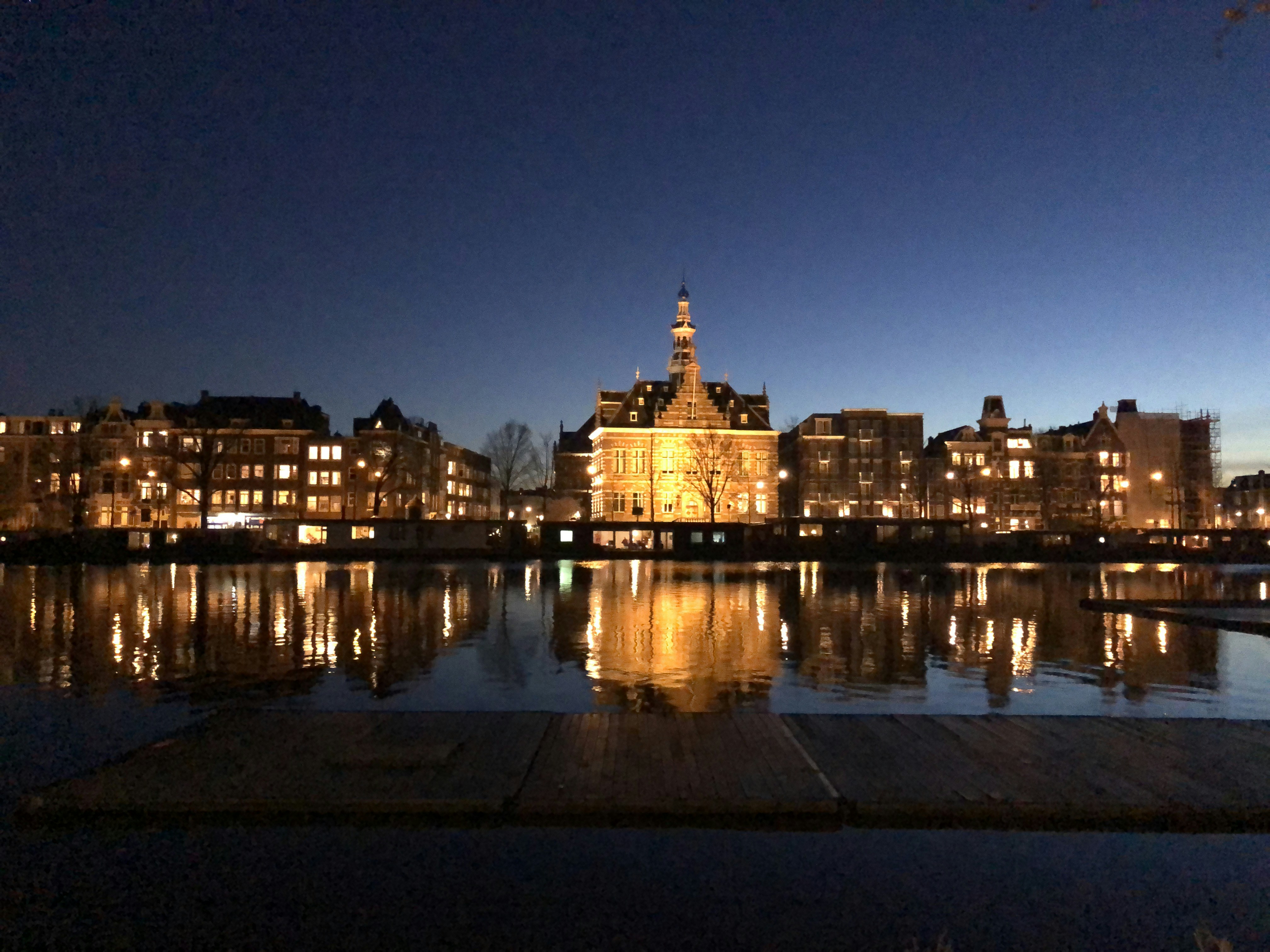 lighted building near body of water during night time