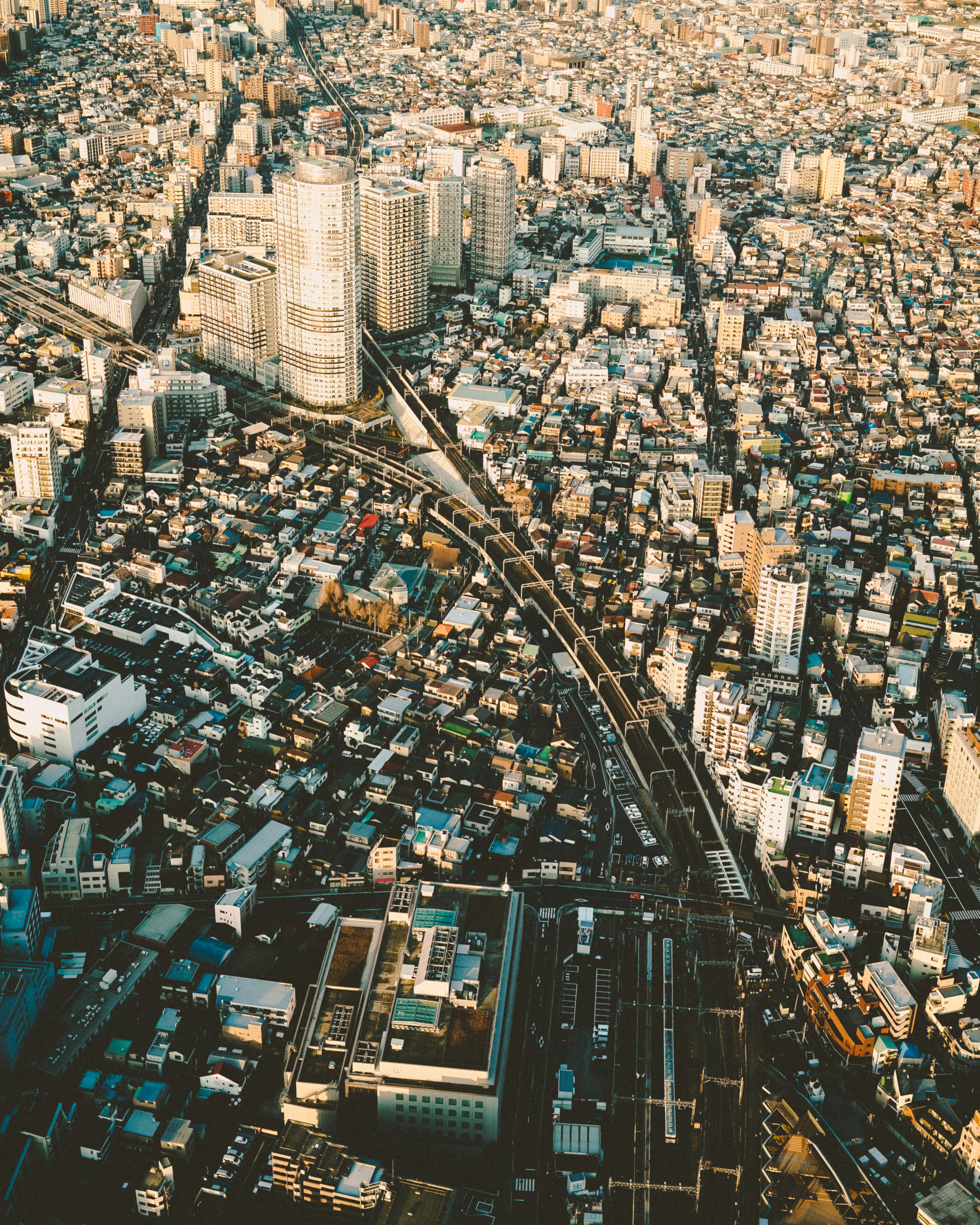 Aerial view showcasing the intricate layout of urban structures and roads, highlighting the contrast between high-rise buildings and densely packed residential areas.