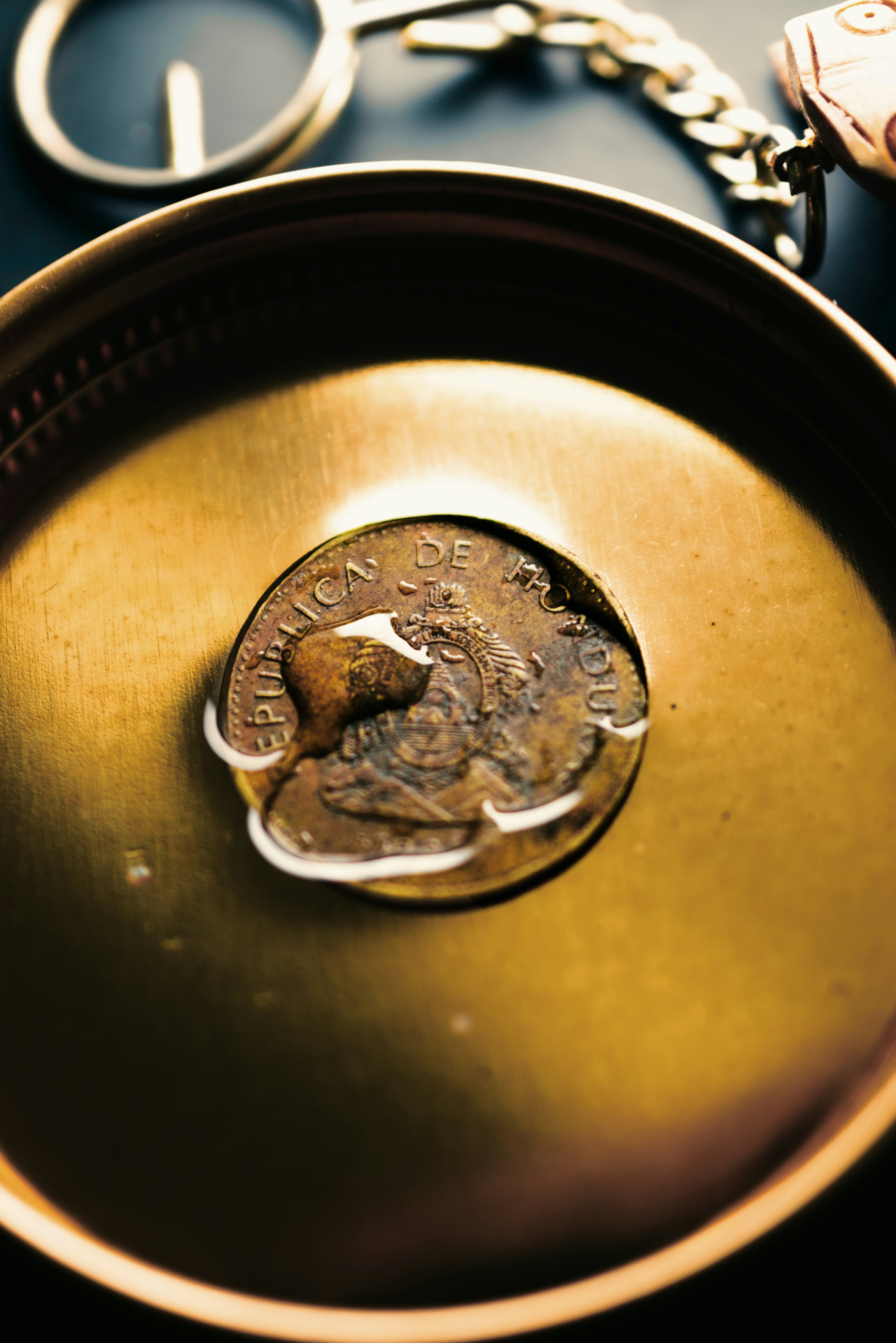 Coin in the Horn: A Close-Up of a Nostalgic Keyring Under Warm Brass