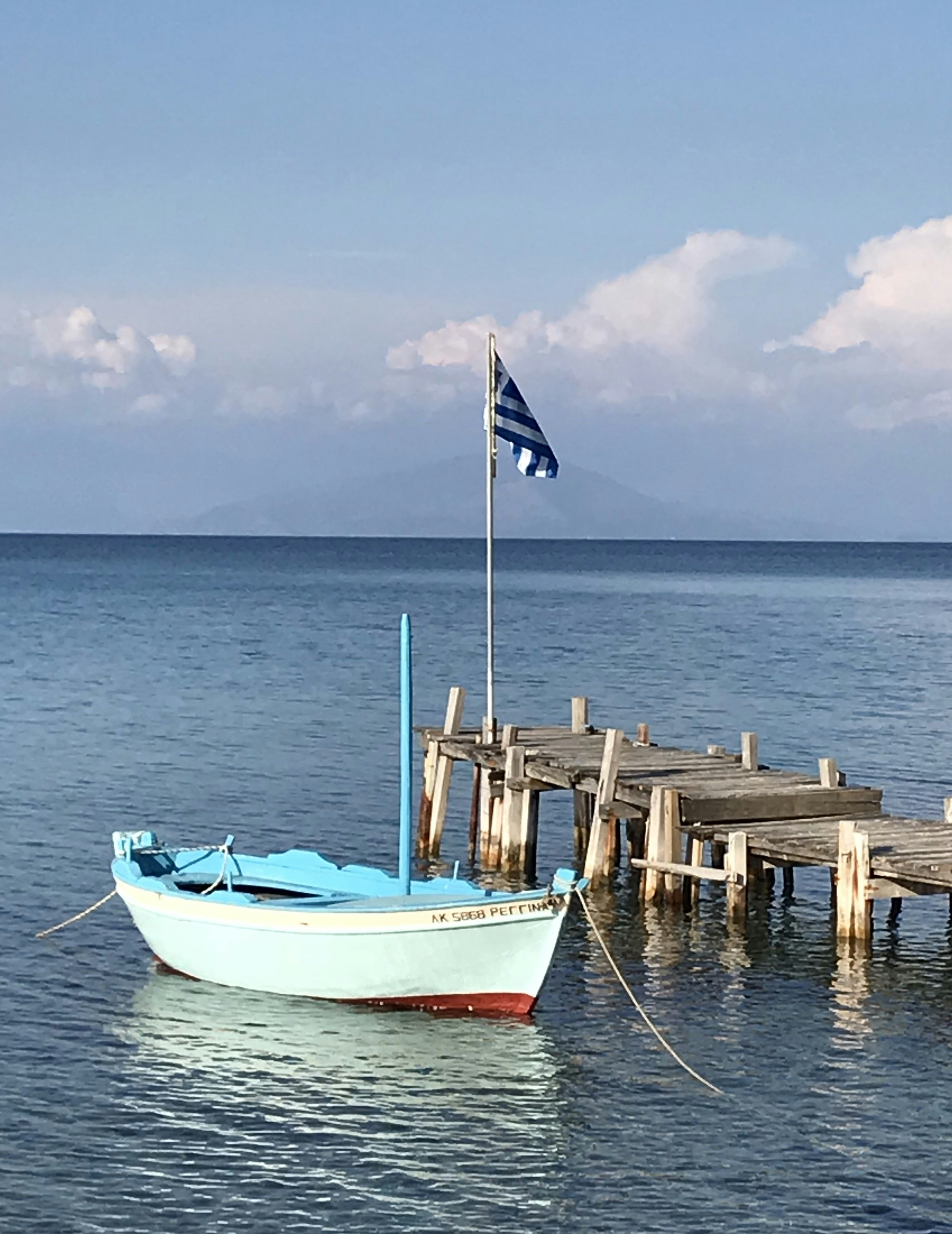 Blue Boat at Quiet Pier Under Clear Sky