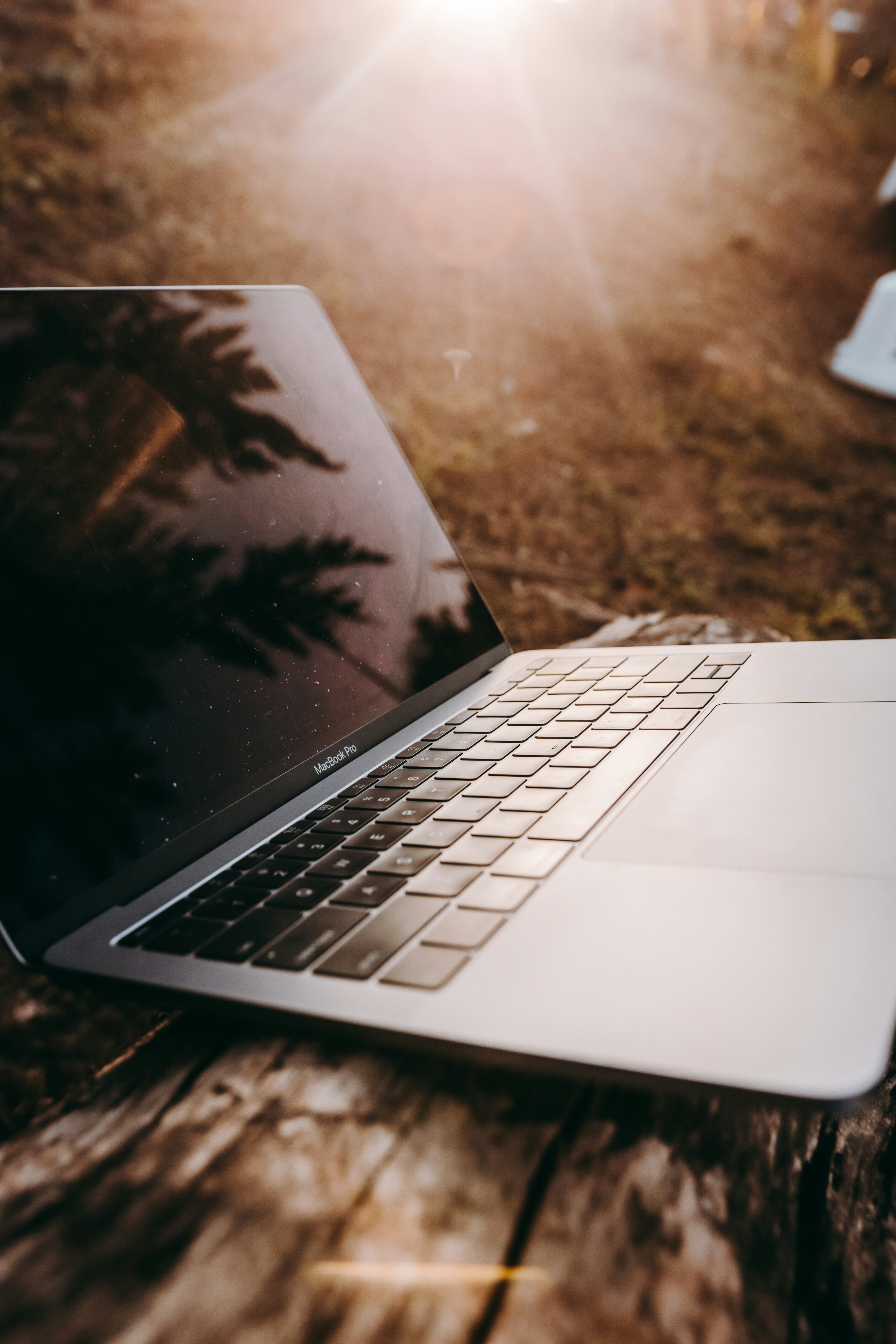 Morning Light on a Silver Laptop Resting on Weathered Wood