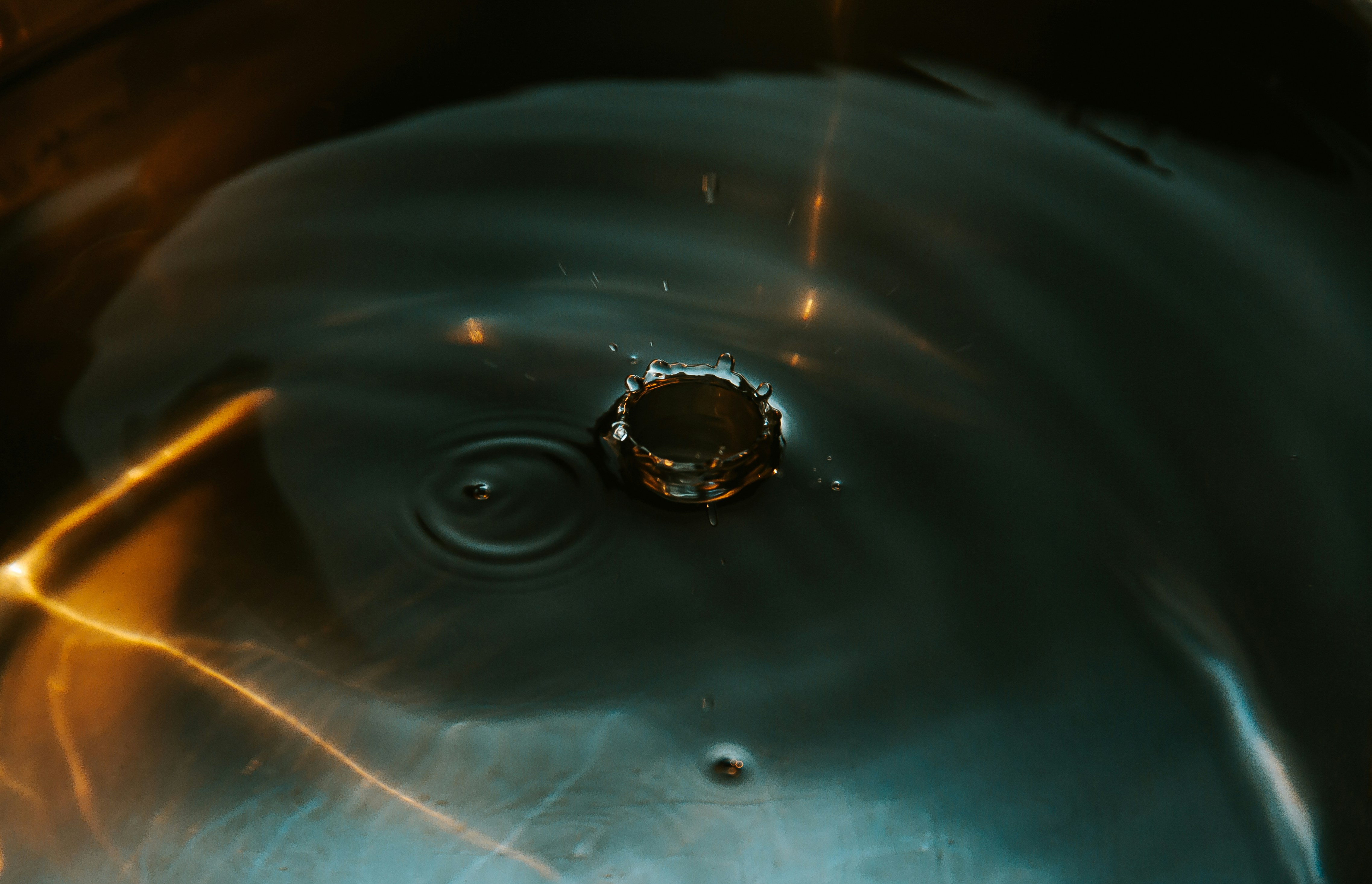 Teal Crown Ripple Under Amber Light