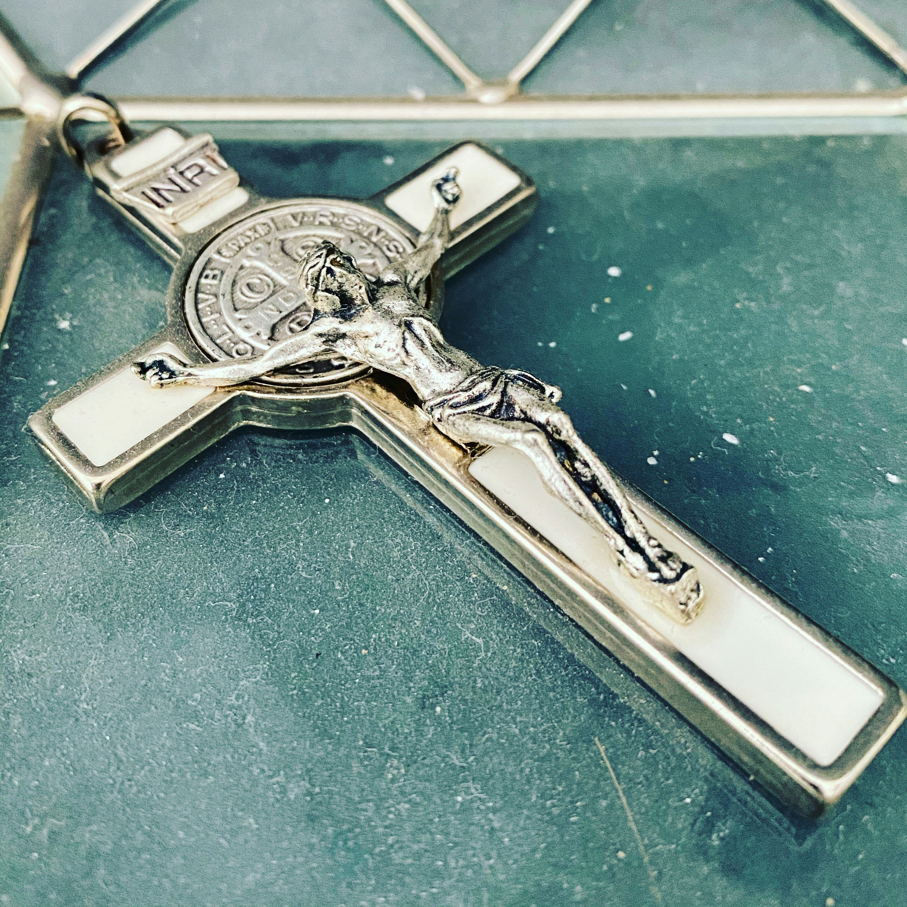 Faithful Reflection: A Silver Cross Amidst Glass