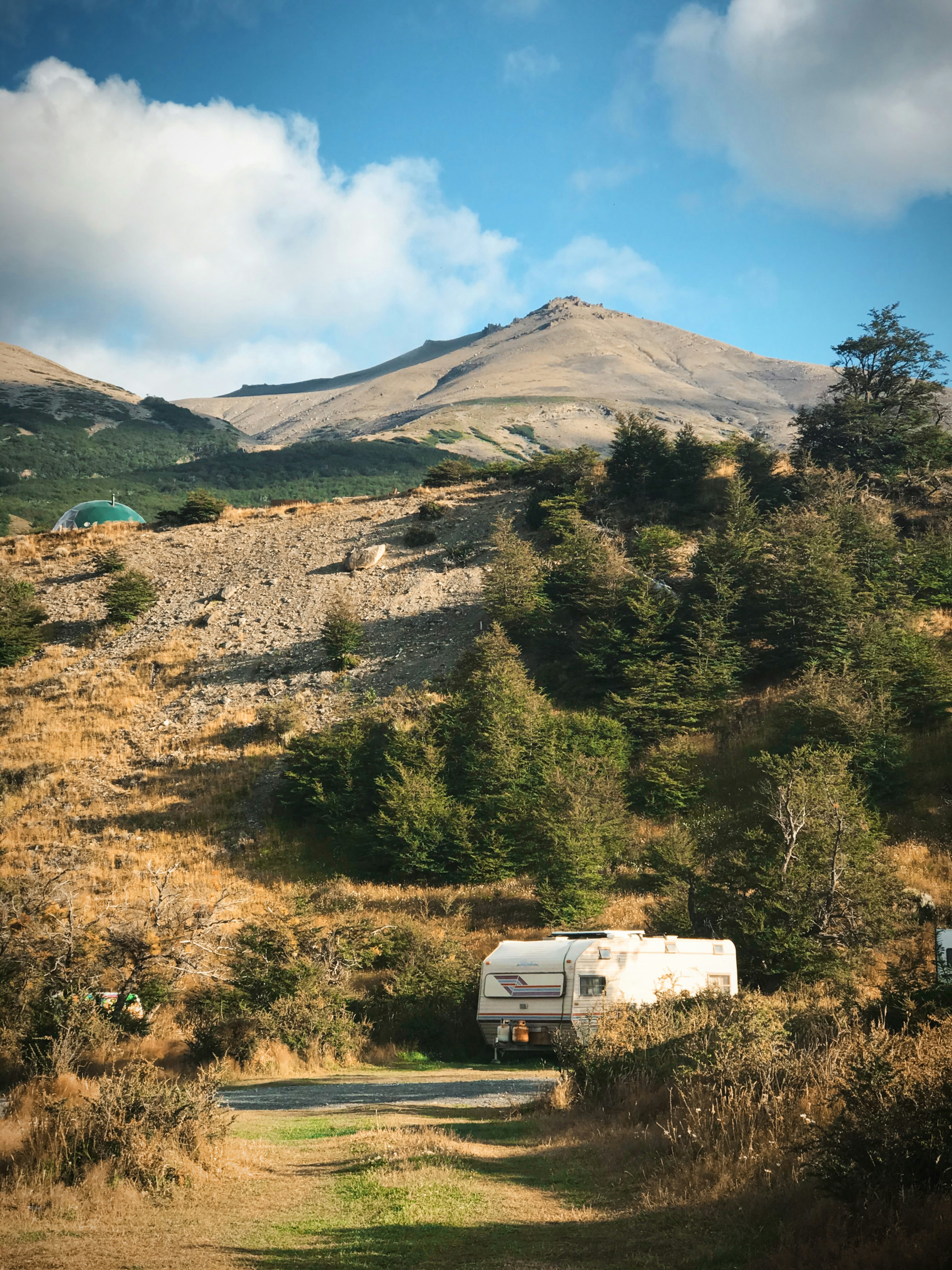 White and gray bus on road near green trees and mountain during daytime ...