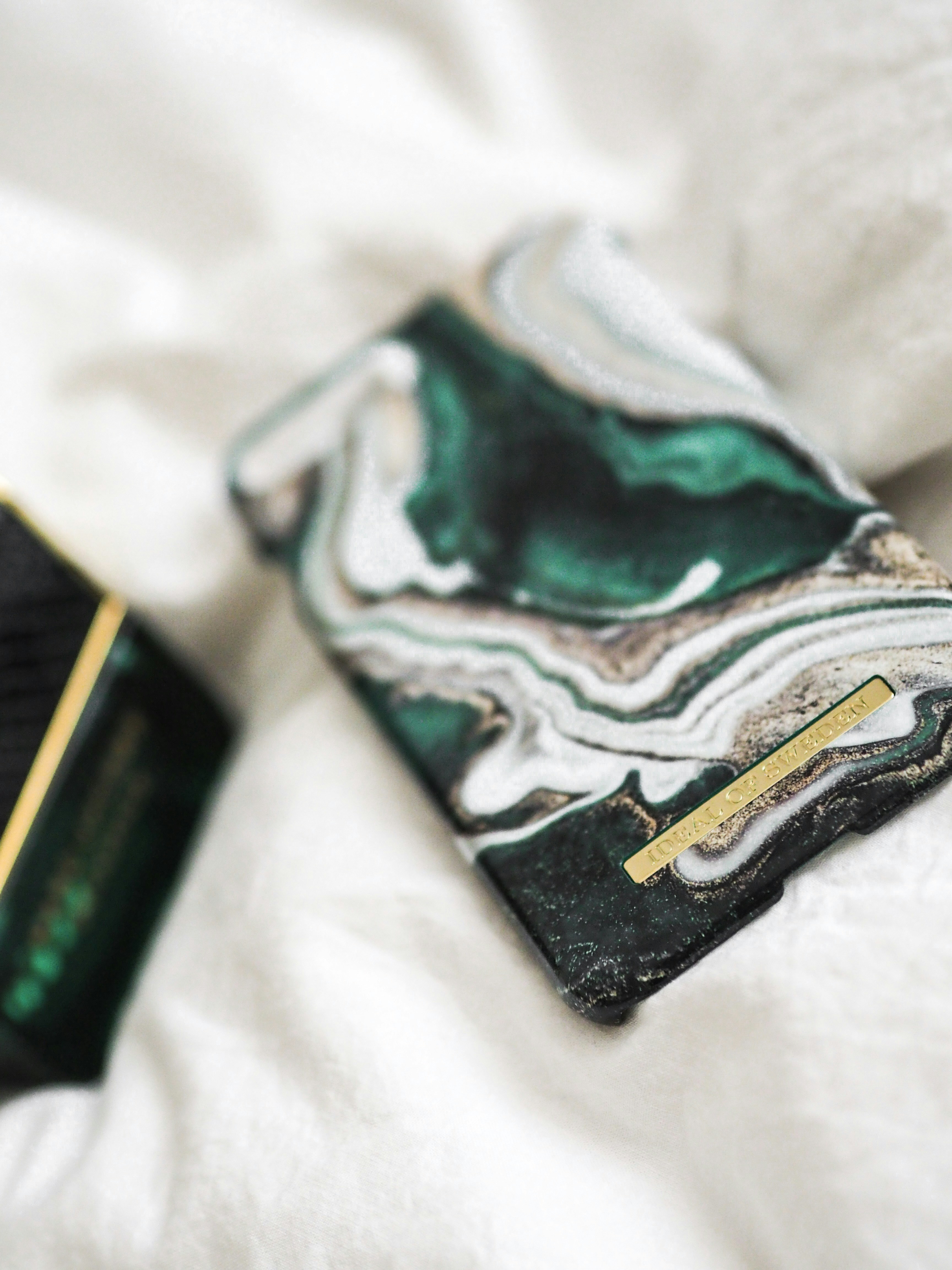 Marbled Green: A Slim Metal Accent Resting on Plush White Linen