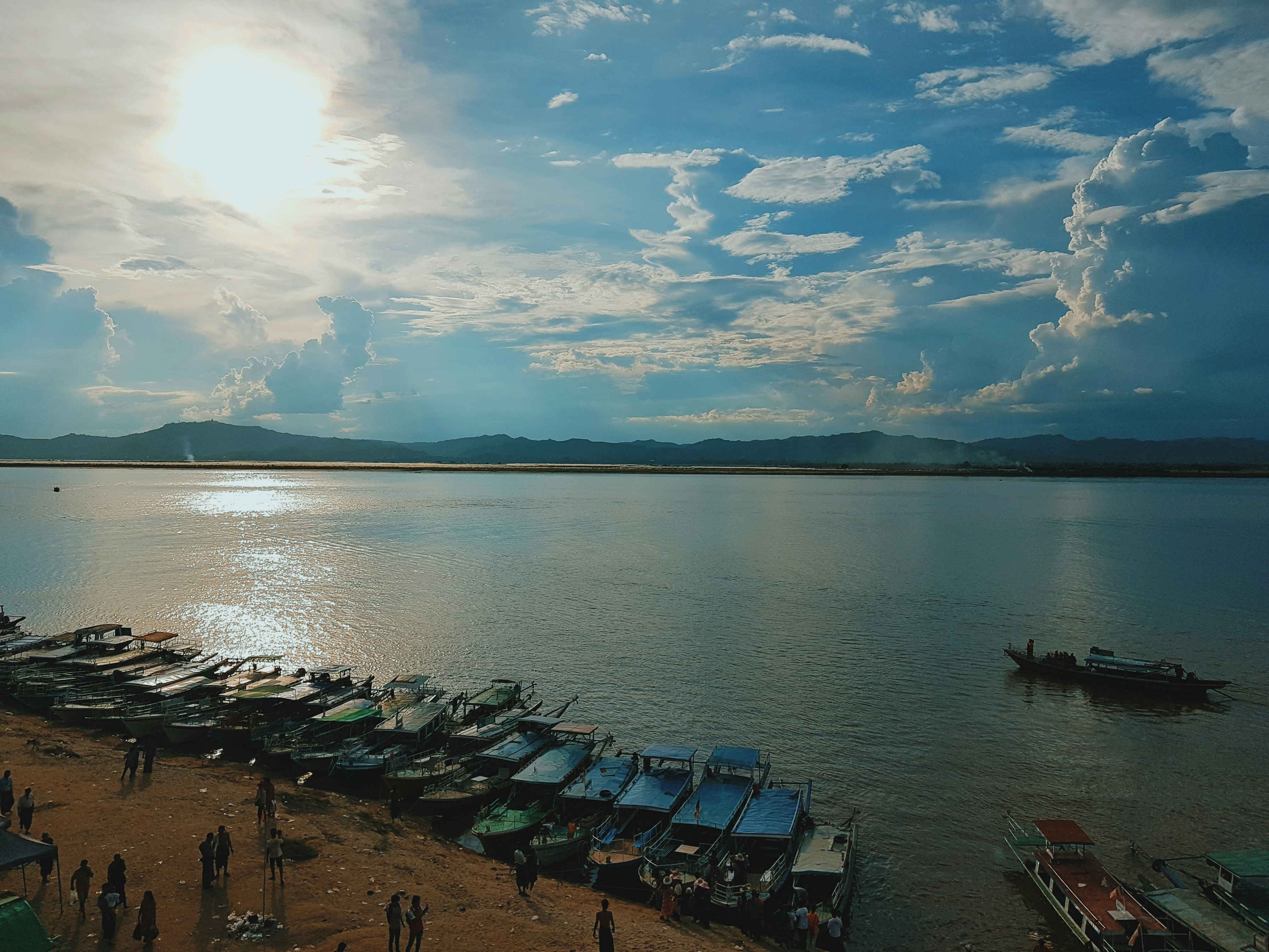 Rows of Canopied Boats Rest Along a Quiet Lakeshore at Sundown