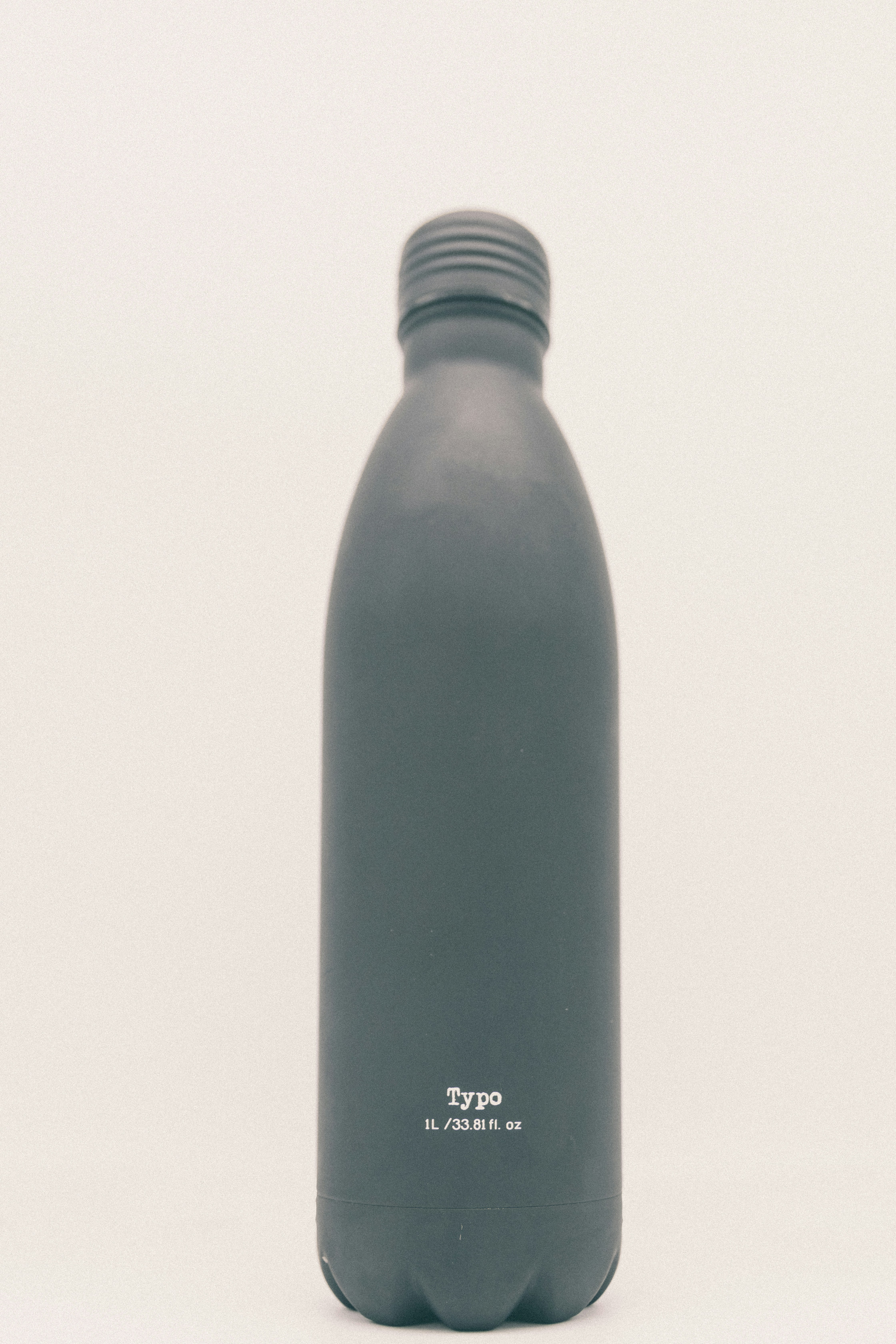 Minimalistic black water bottle with a textured surface and clear branding at the base. Ideal for eco-conscious consumers.
