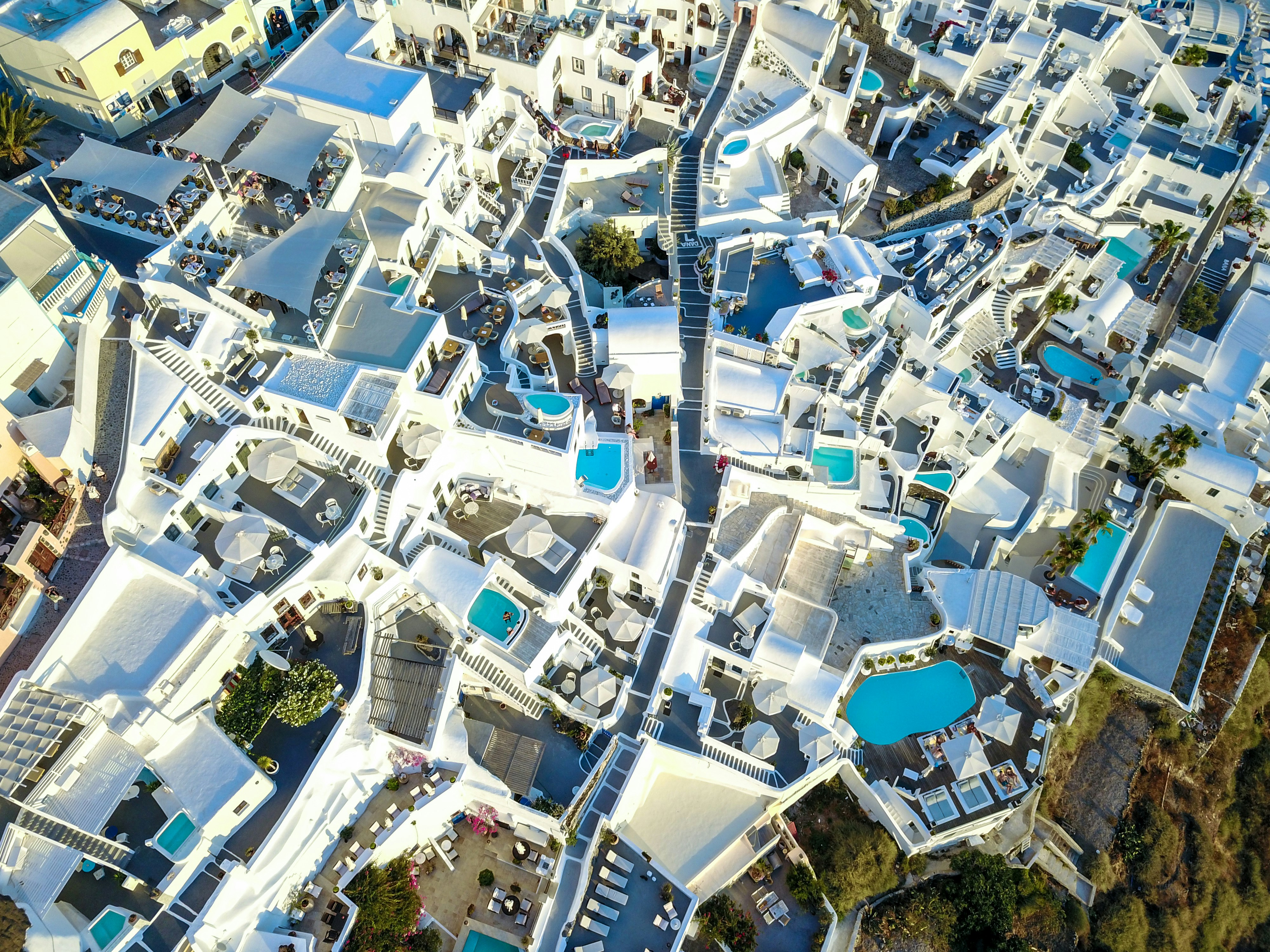 Intricate layout of Santorini's whitewashed buildings and pools, showcasing the unique architectural style of the island.