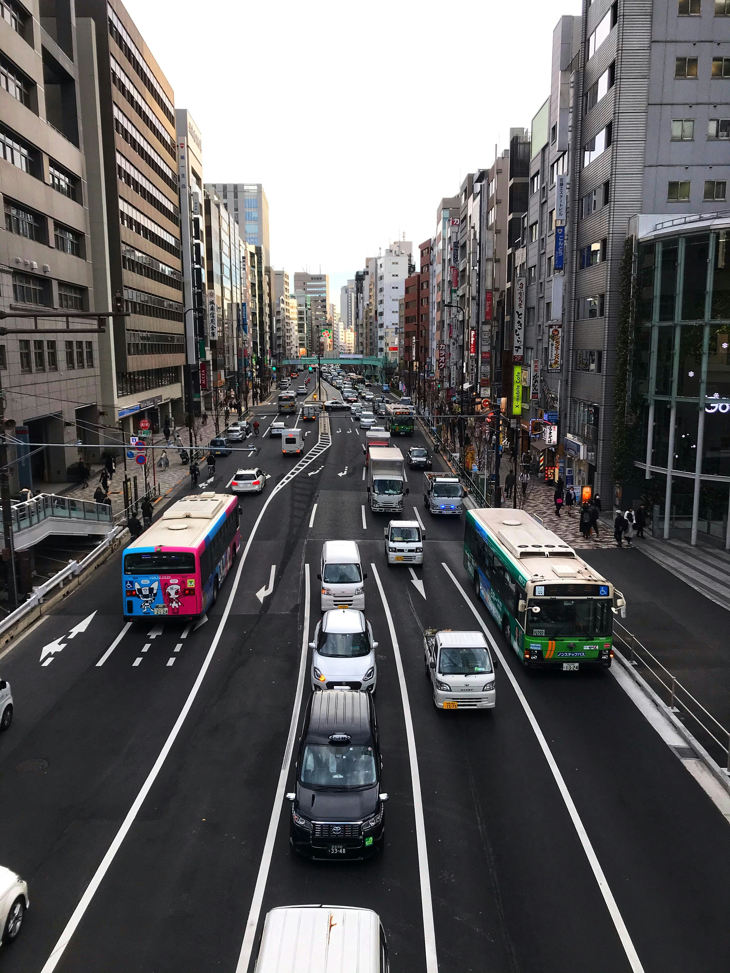 Cars on road between high rise buildings during daytime photo – Free ...