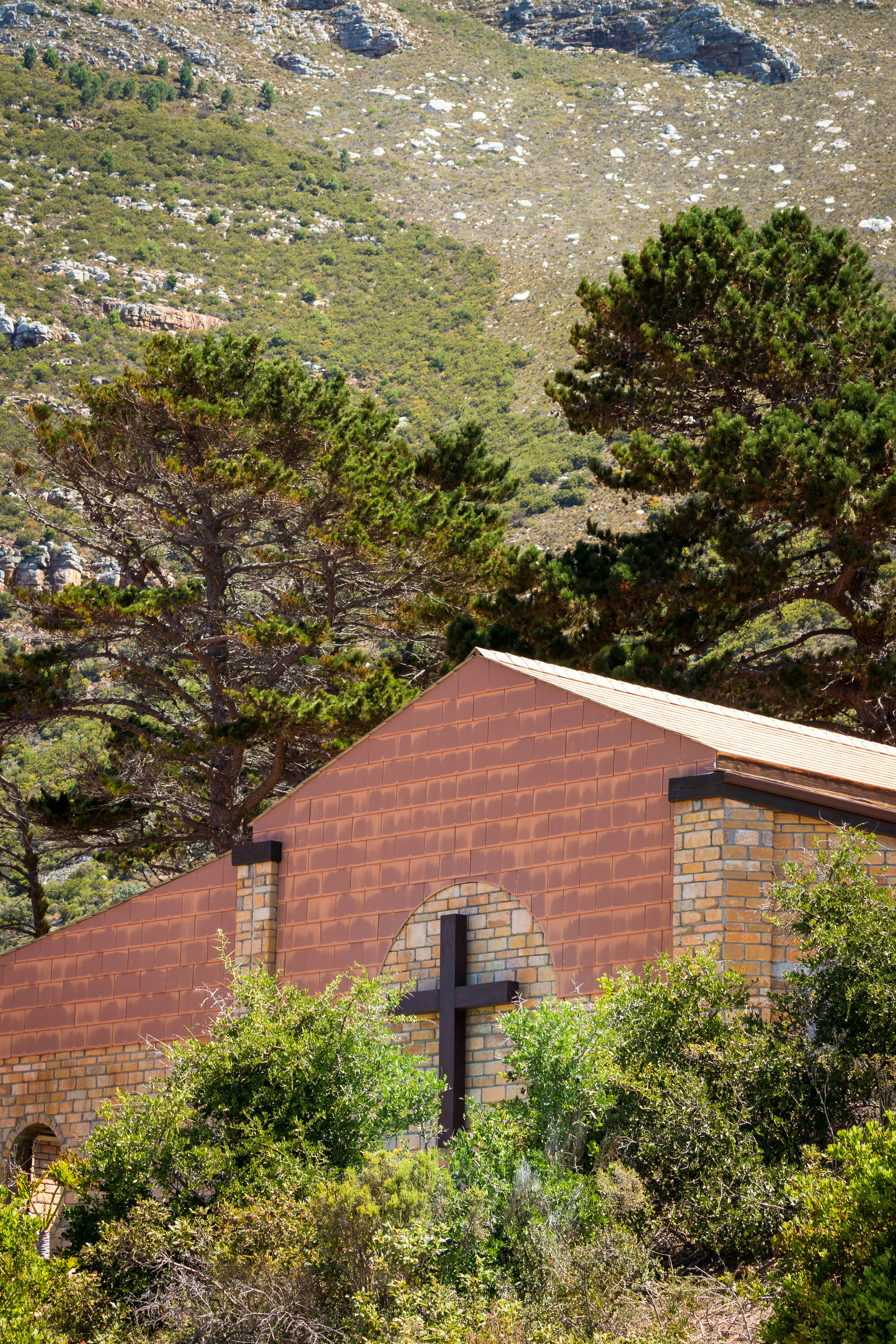 brown brick house near green trees during daytime