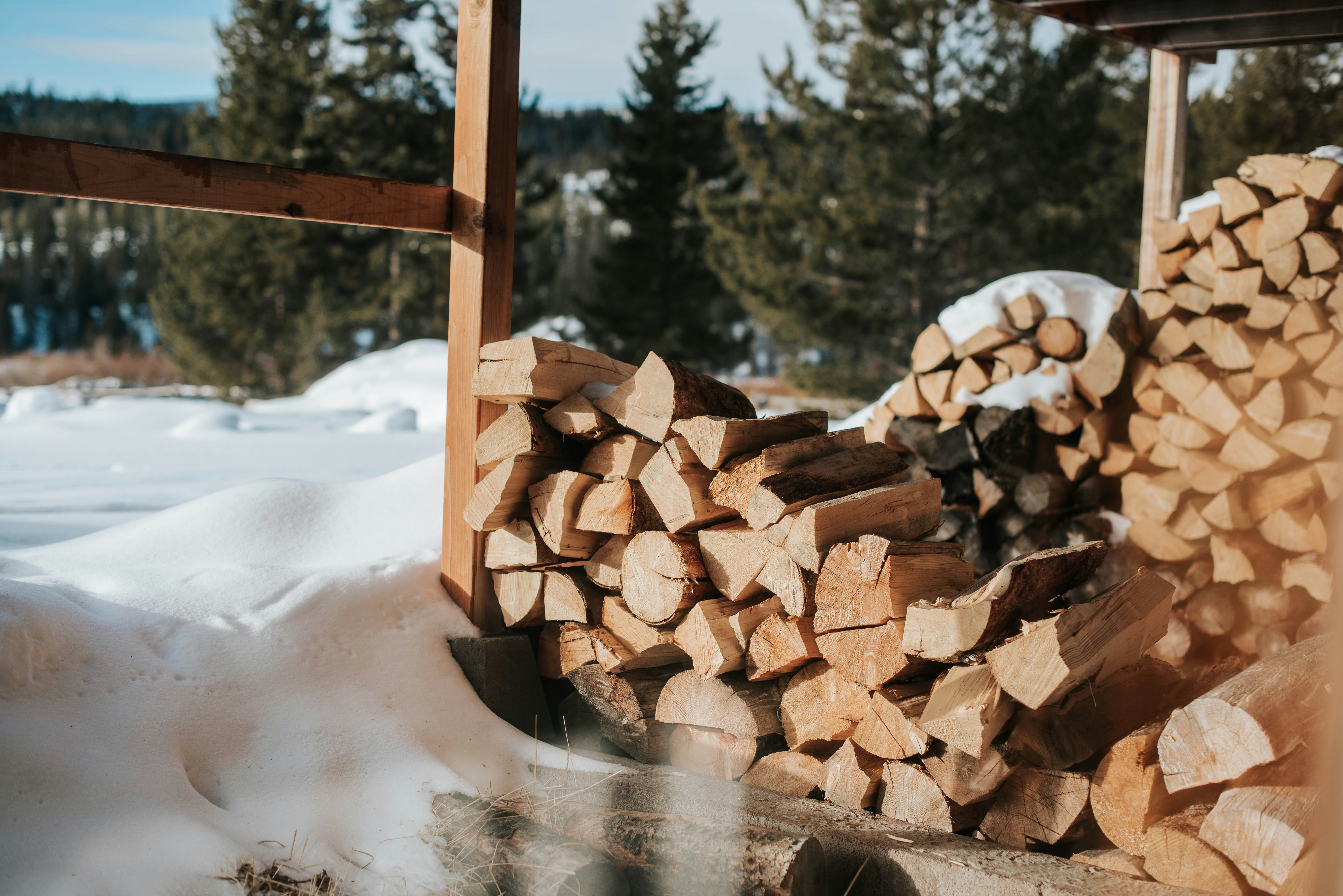 Winter Woodpile Under Shelter, with an Axe Resting in the Foreground