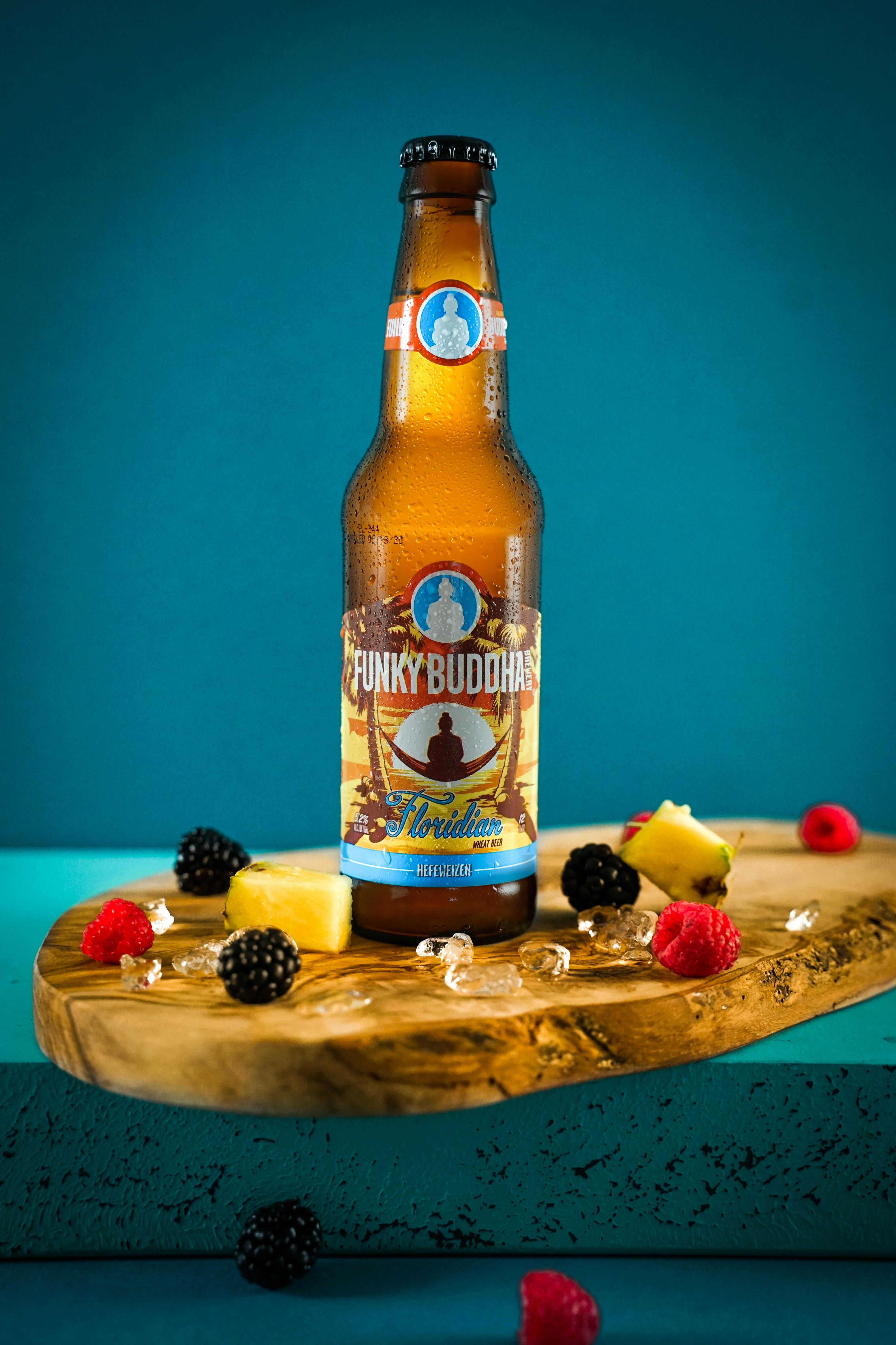 Teal Backdrop Still Life: Funky Buddha Bottle on a Wooden Board