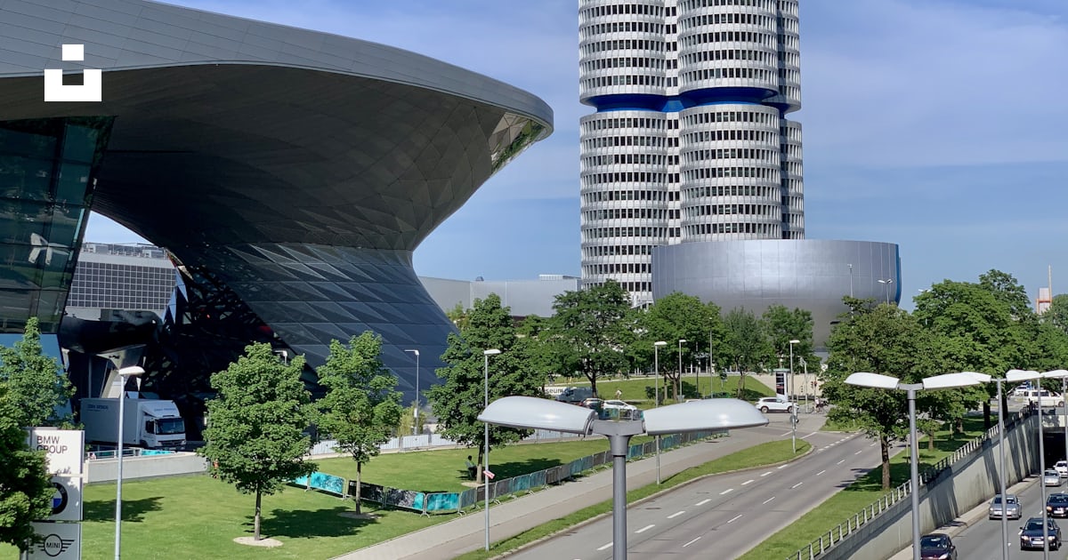 낮에는 푸른 잔디밭 근처의 흰색과 파란색 콘크리트 건물 사진 Unsplash의 무료 자동차 이미지