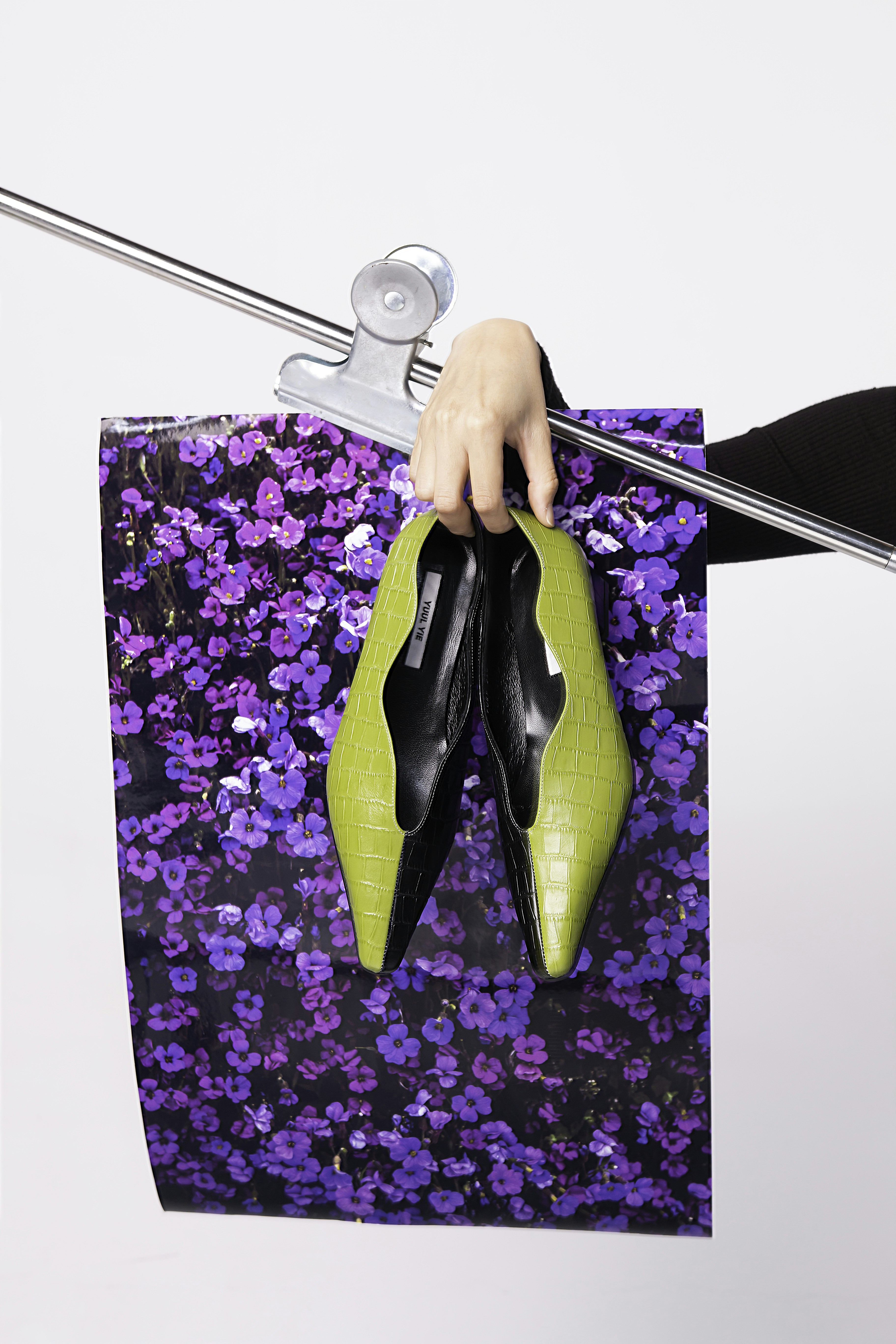 Lime-Green Heels Rest on a Violet Floral Poster in Studio Still Life