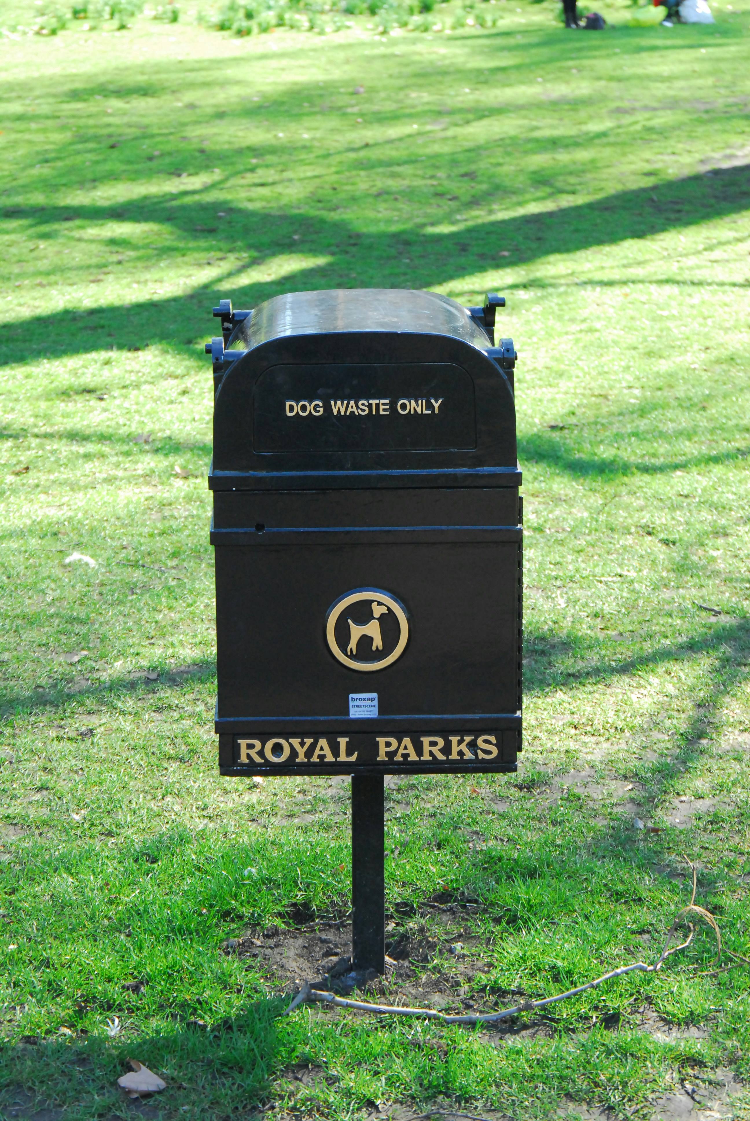 Sunlit Sentinel: The Royal Parks Dog-Waste Bin Framing a Quiet Green