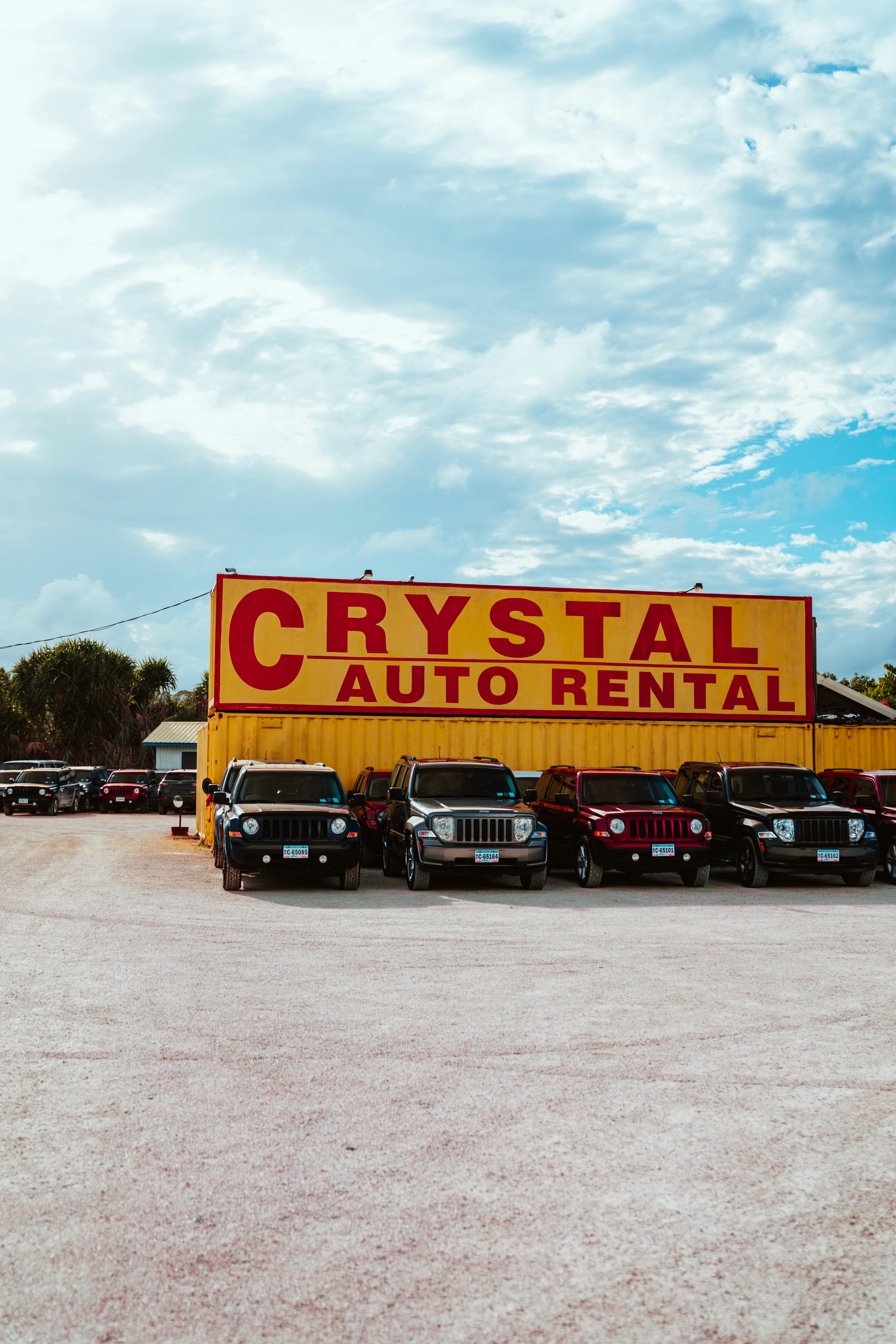 Crystal Auto Rental: Row of Jeeps in Front of a Bright Yellow Sign