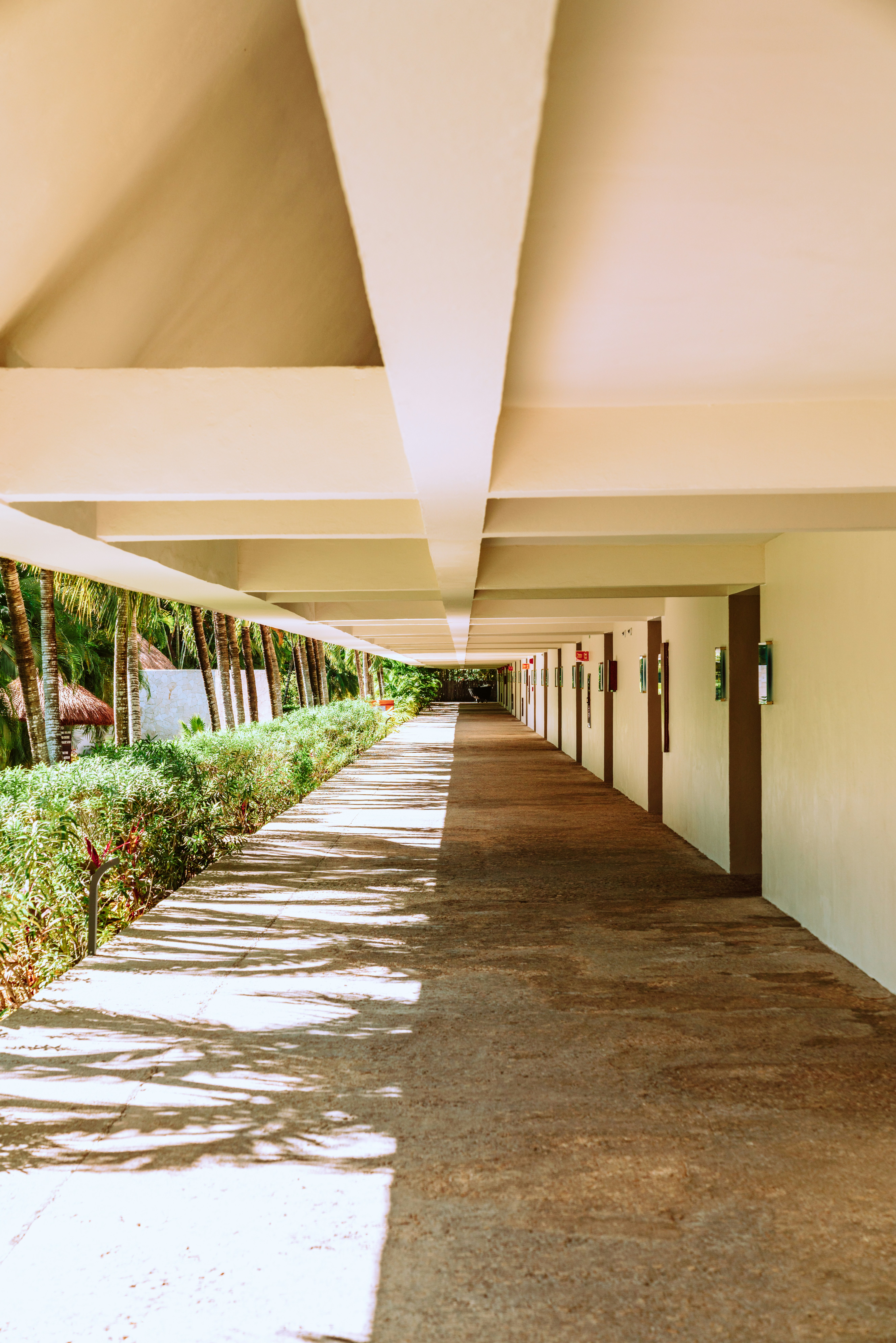 Hotel room doors along a long outdoor hallway.