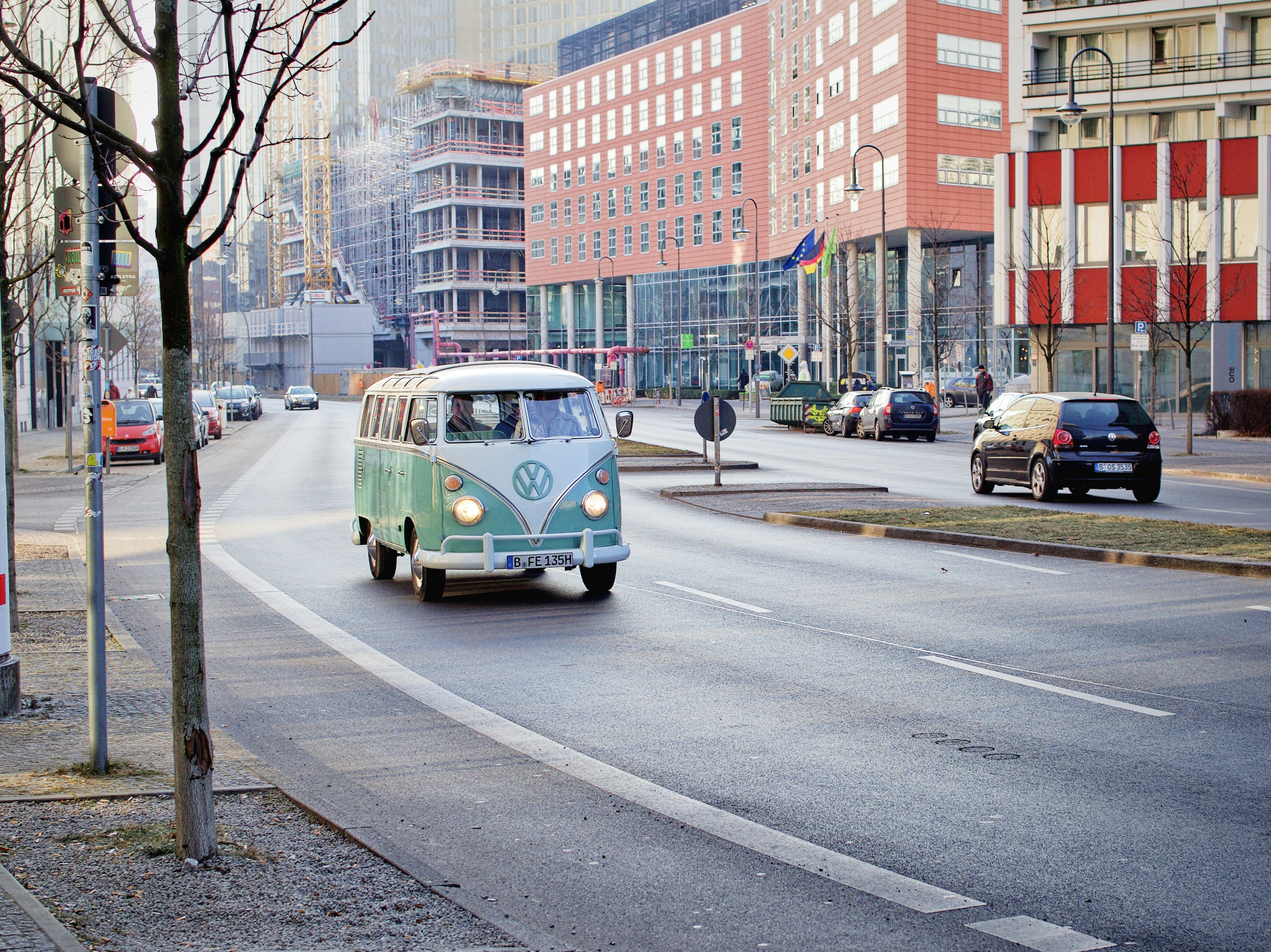Pastel VW Bus on a Quiet City Boulevard