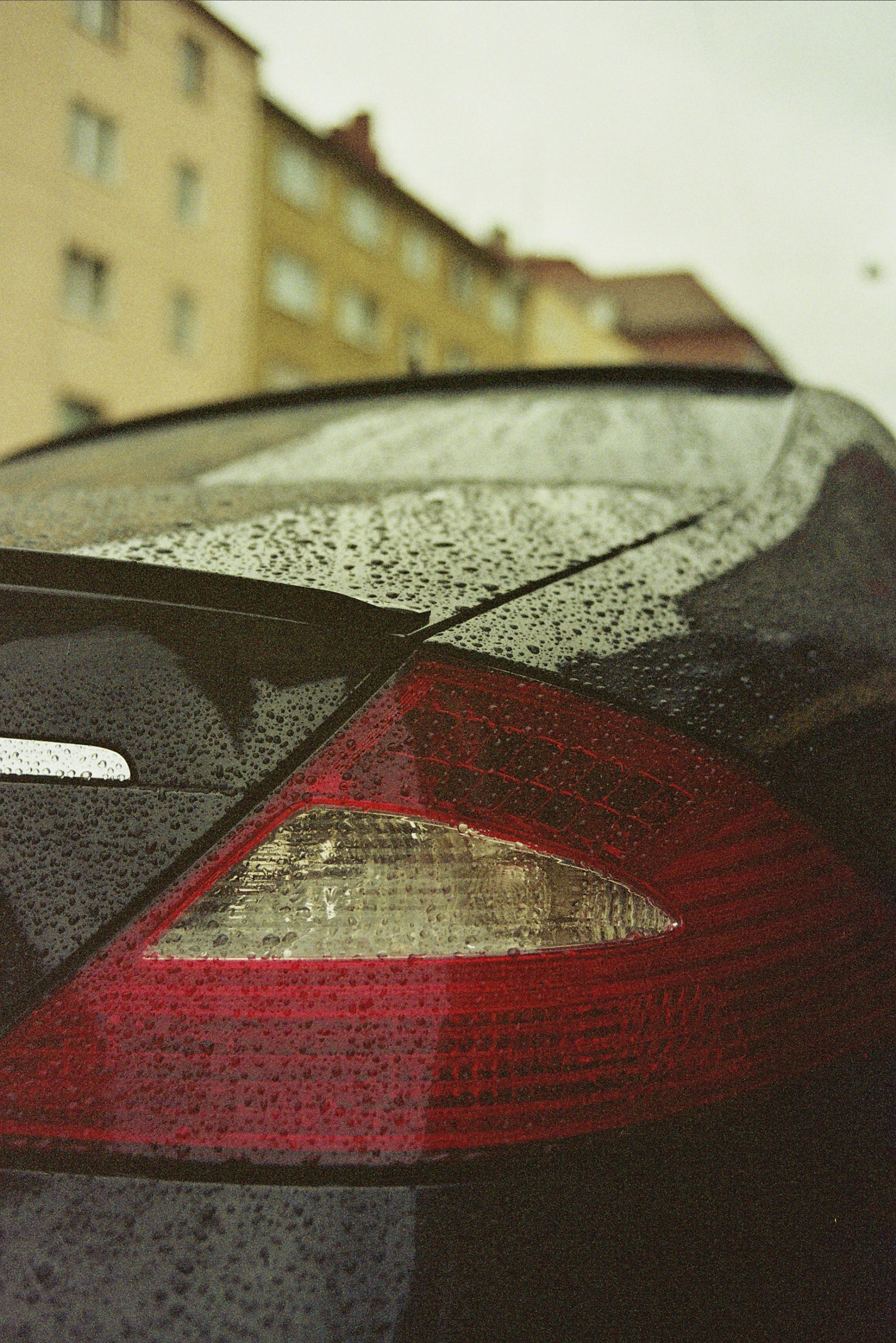 Chrome Braided Rain: The Car's Taillight in a Rain-kissed Evening