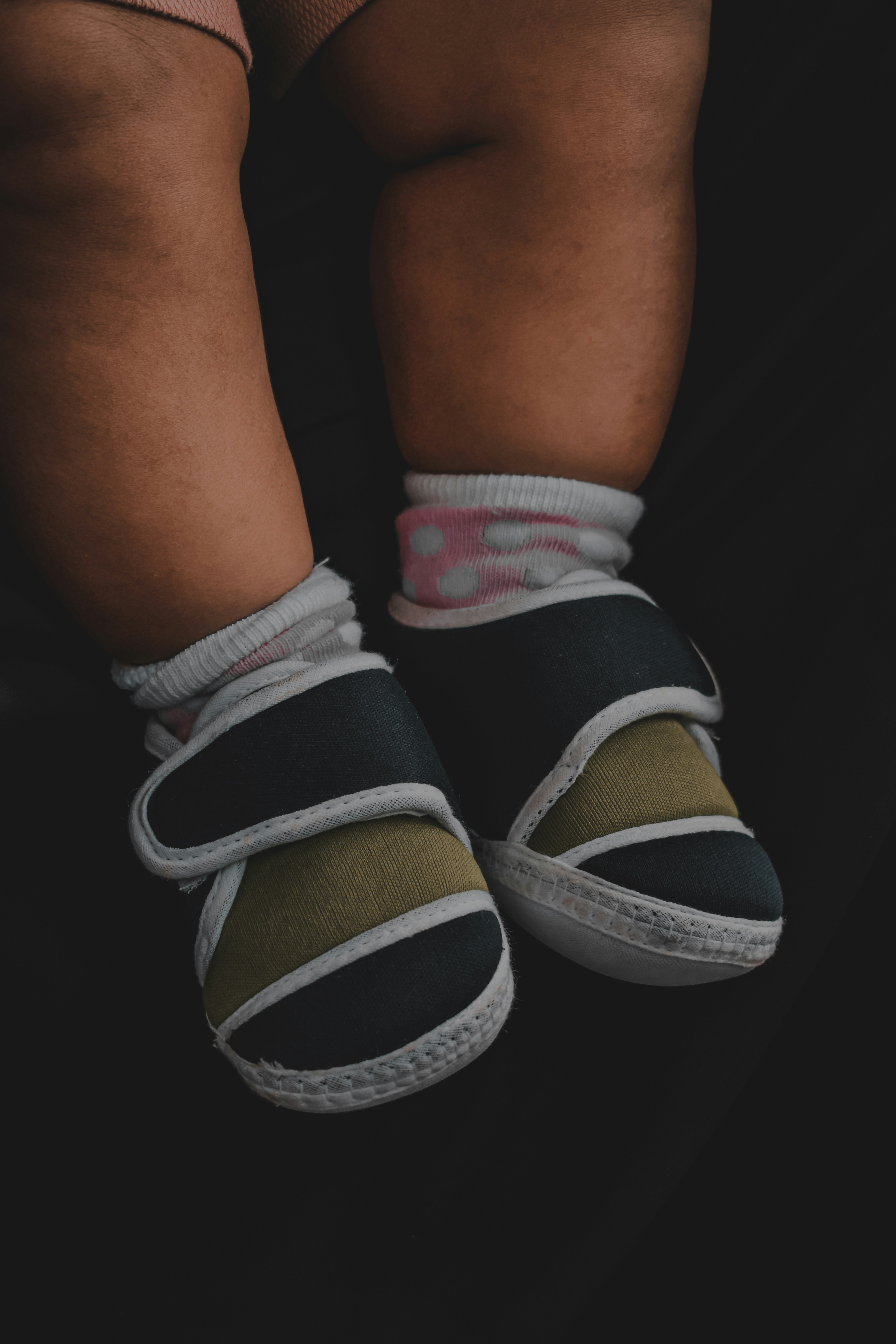 Tiny Steps in the Dark: Baby Shoes on a Velvet Black Stage